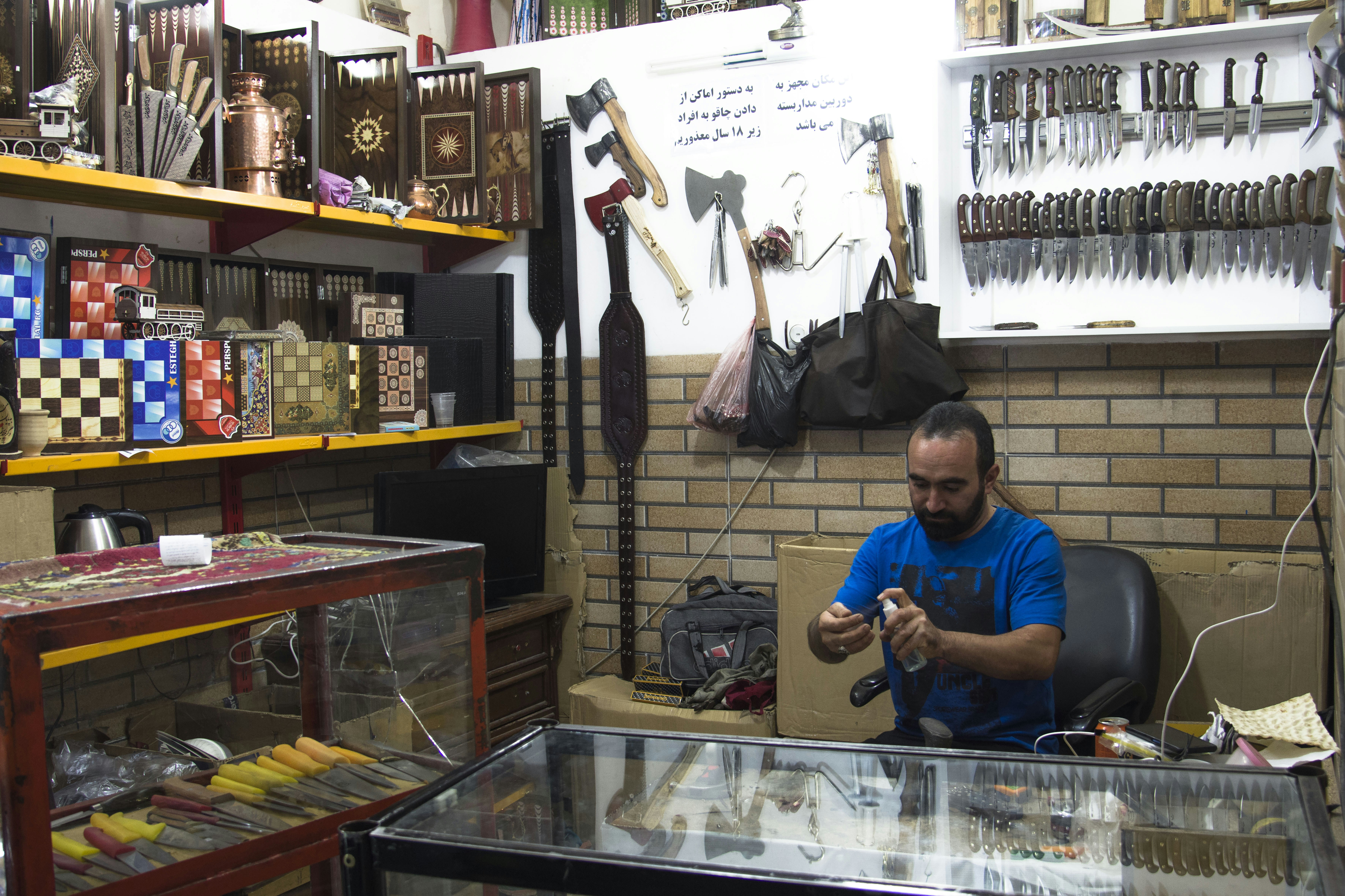 Blue-Shirt Craftsman at a Knife Shop Counter