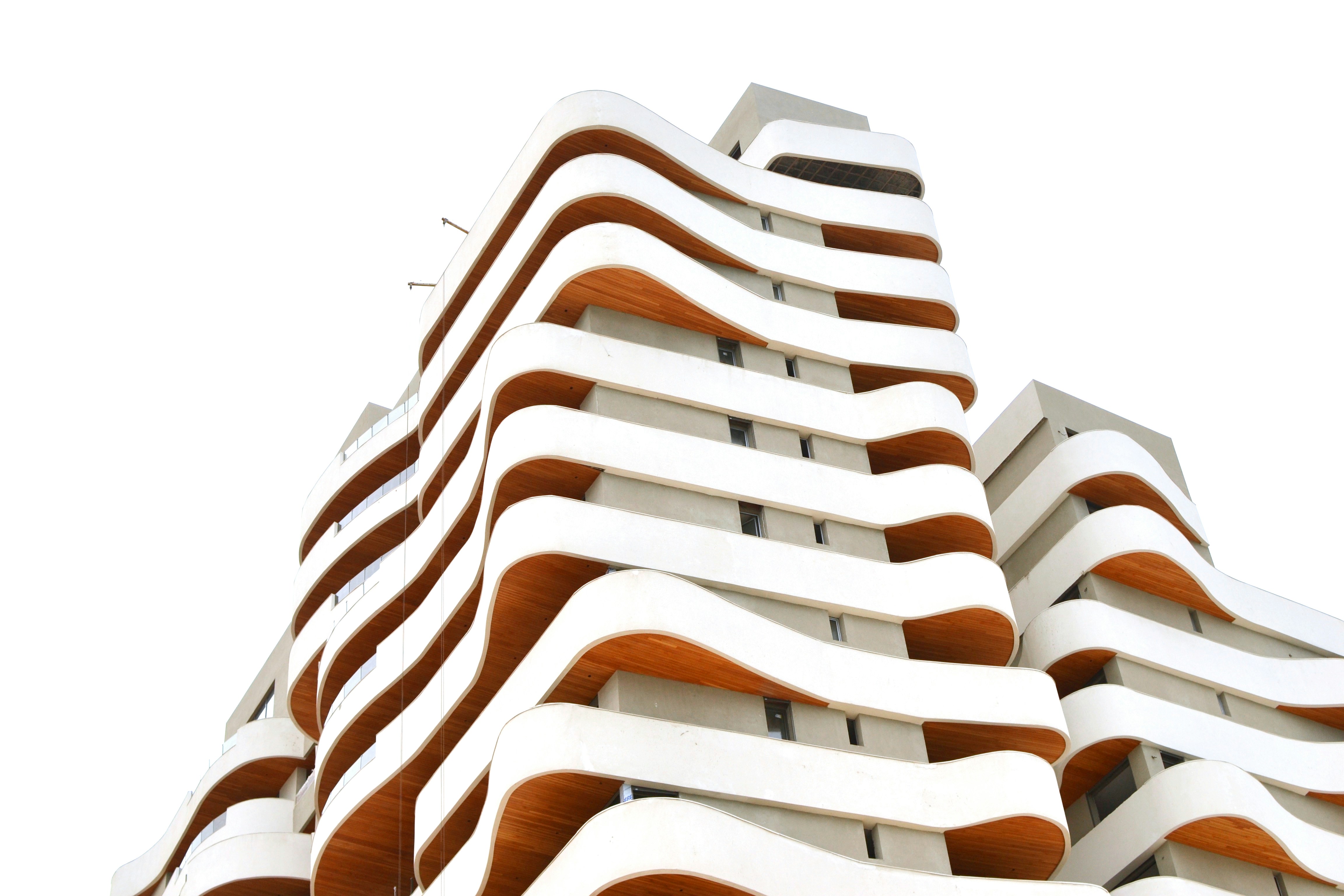 Curved white balconies of a modern building against a clear sky.