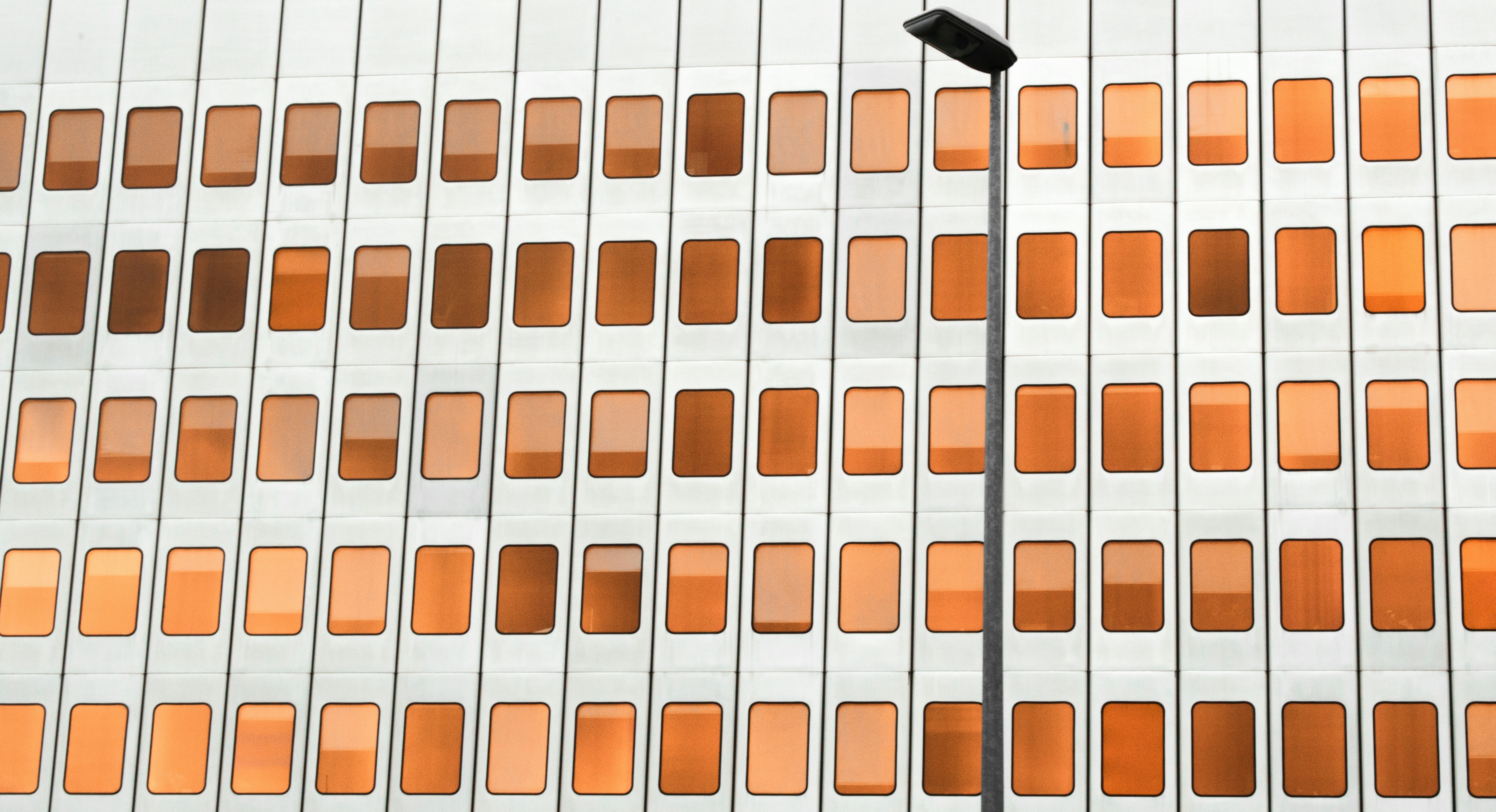 Orange tile mosaic facade with a lone street lamp