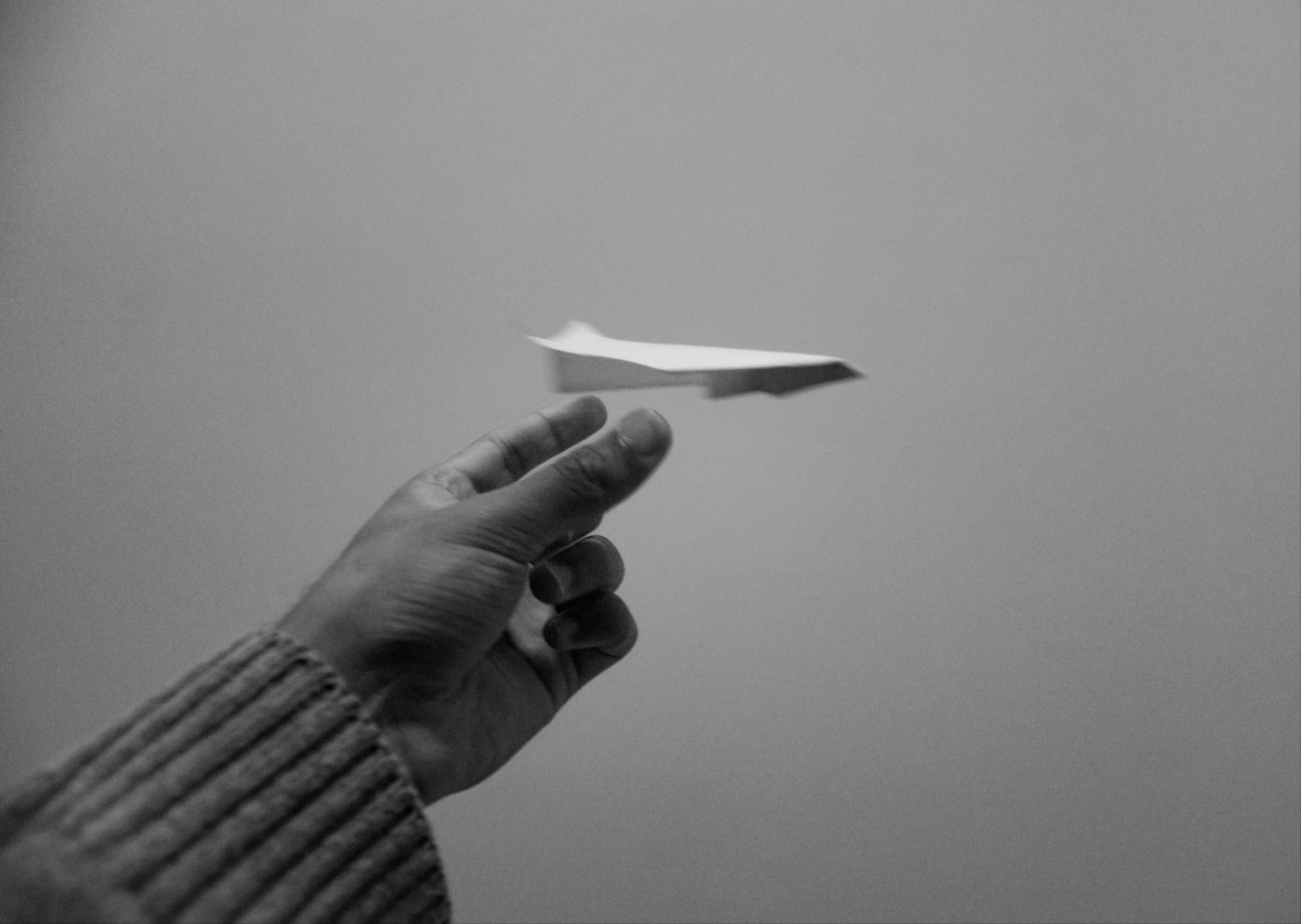 person holding white paper plane