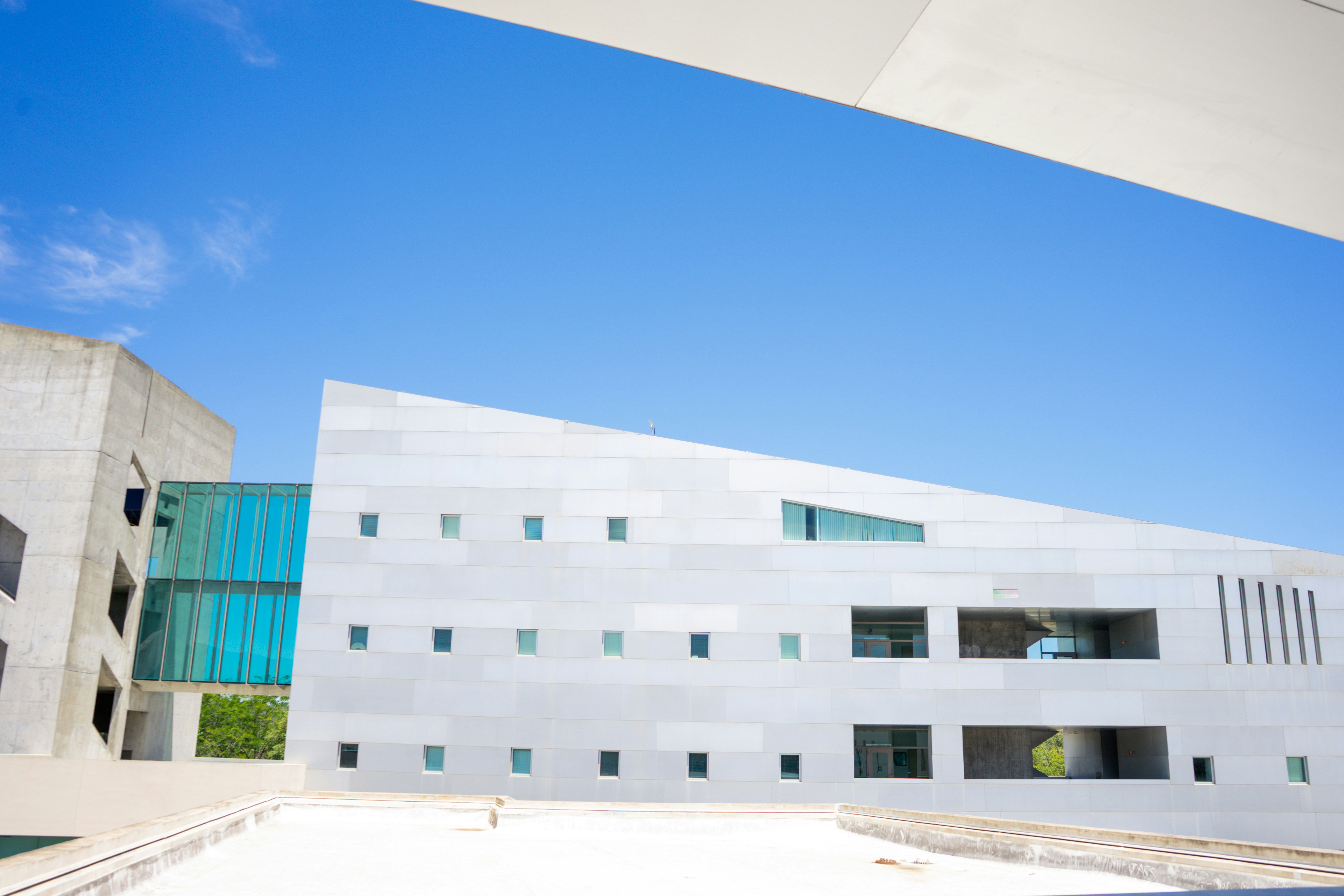 Contemporary building with geometric lines and glass accents under a clear blue sky.