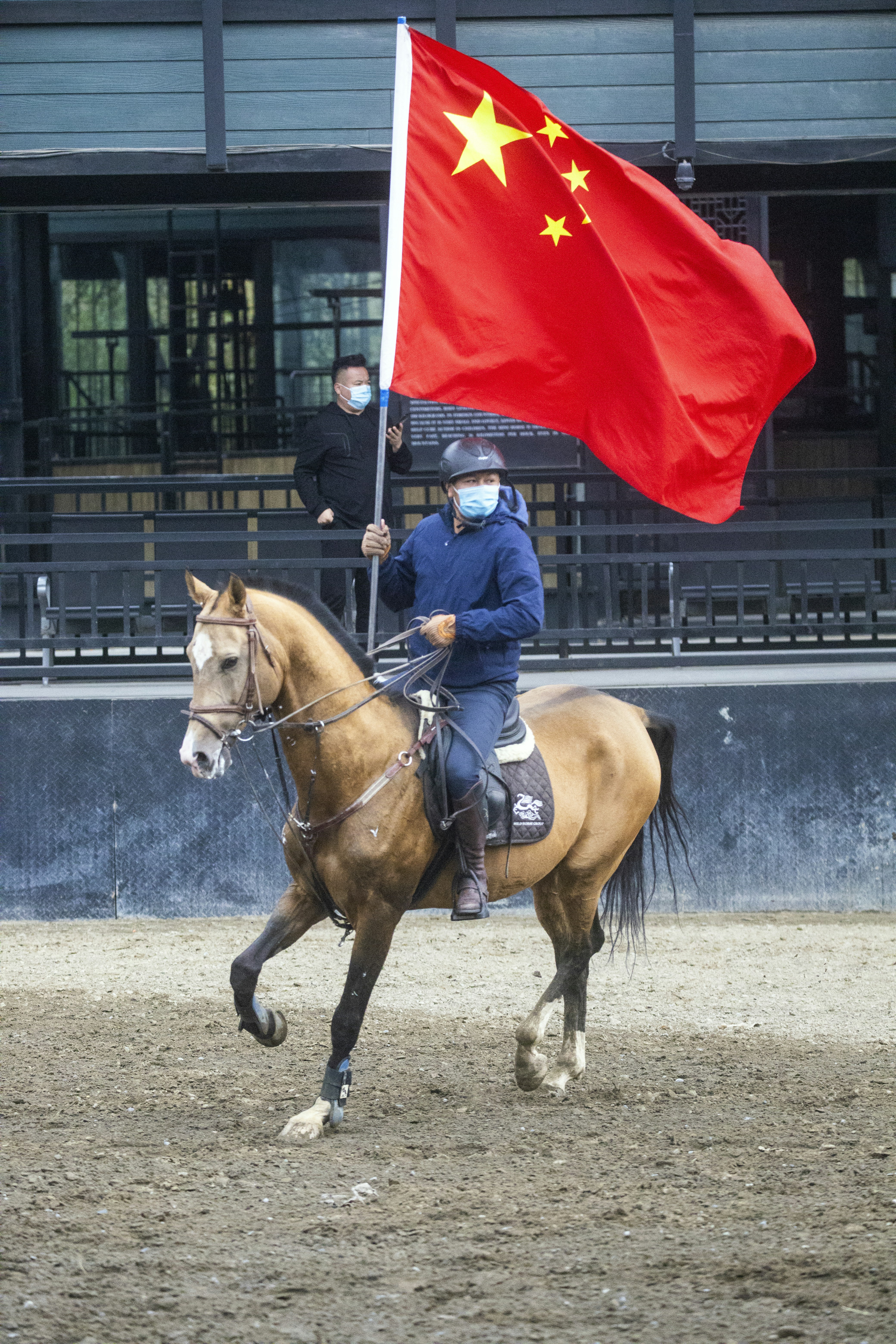 Flagbearer on horseback amid a public square