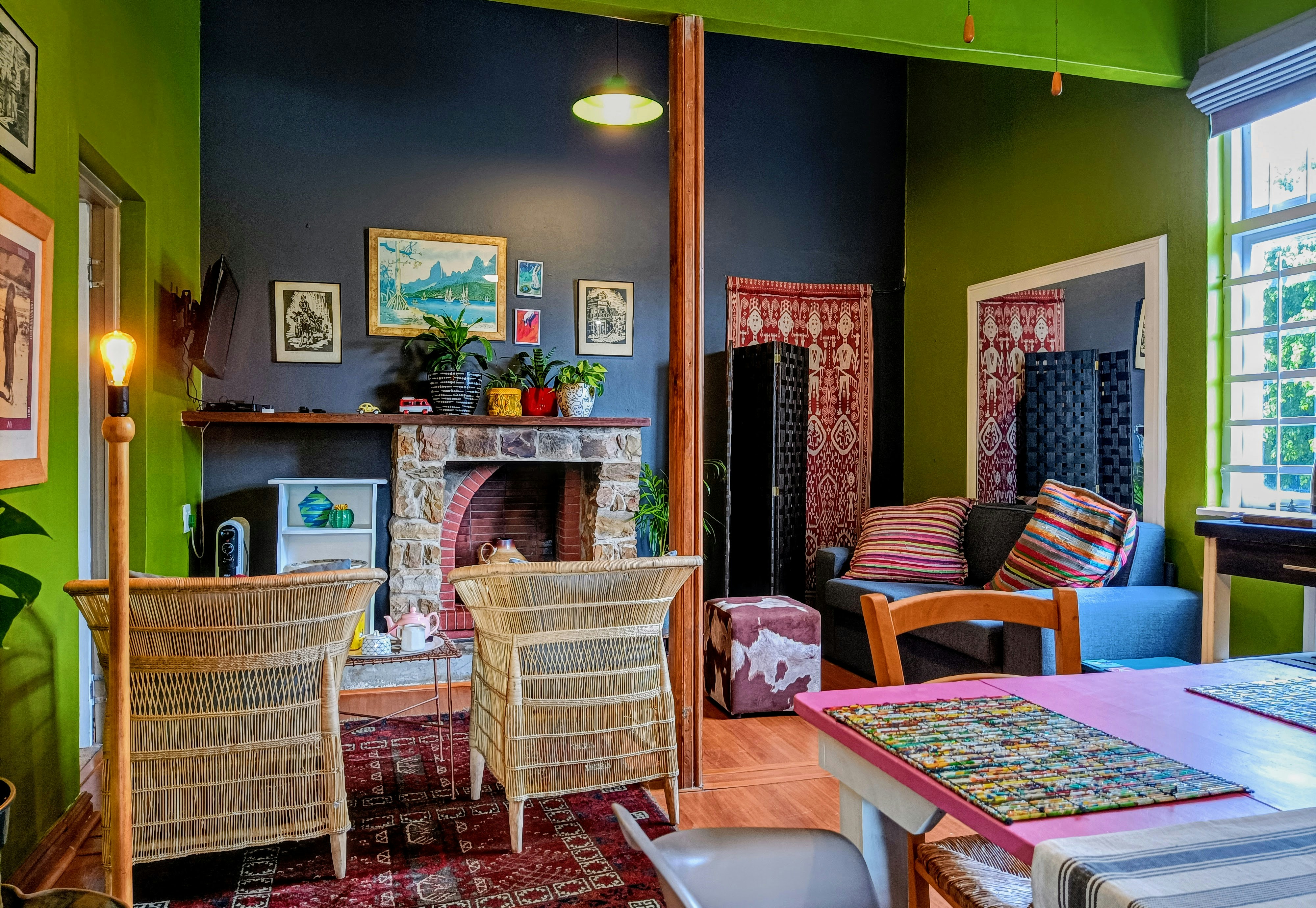 Cozy living room chorus: vibrant greens, classic fireplace, and a sunny window