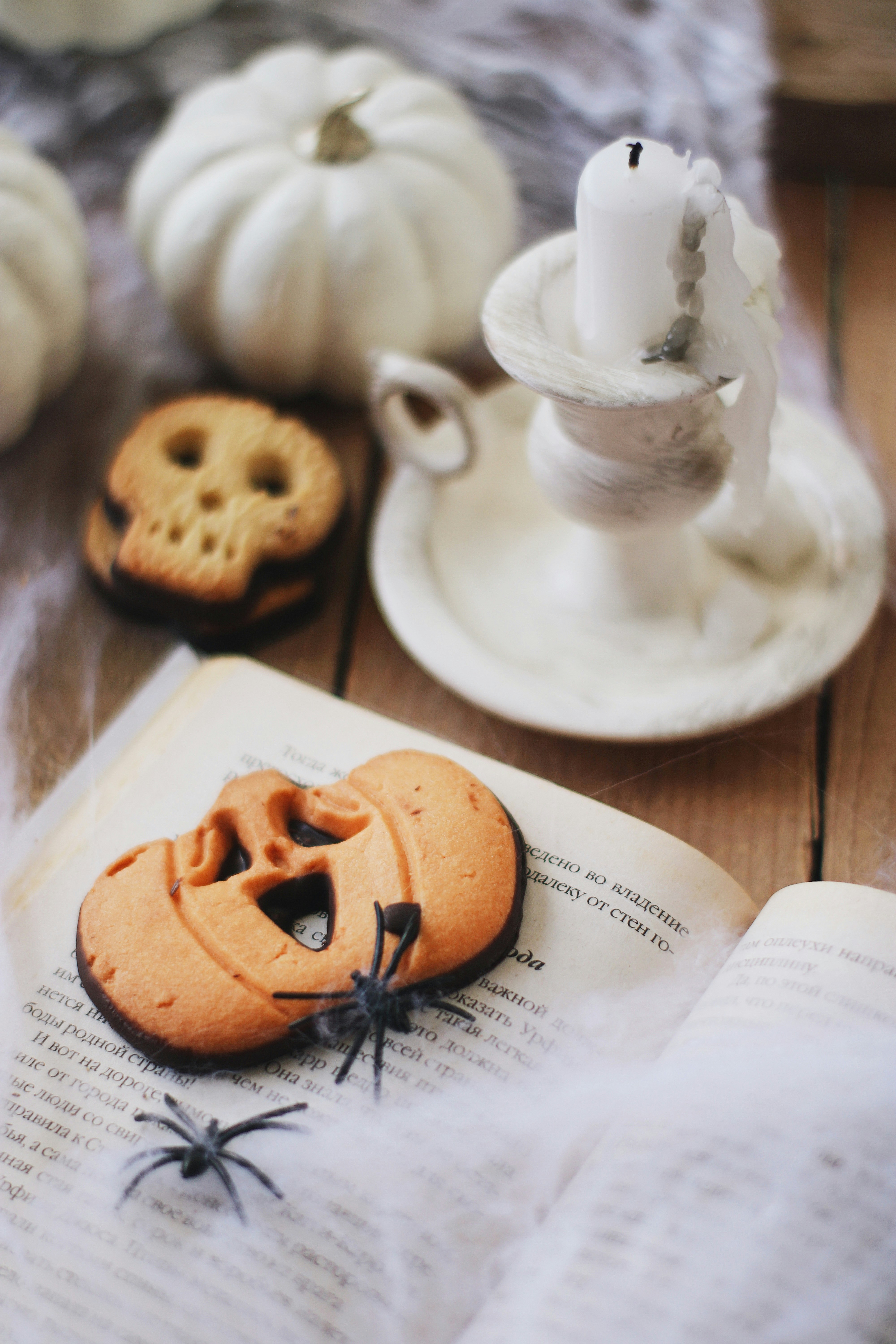 Pumpkin Cookie on an Open Book Beneath a Quiet Halloween Candlelight