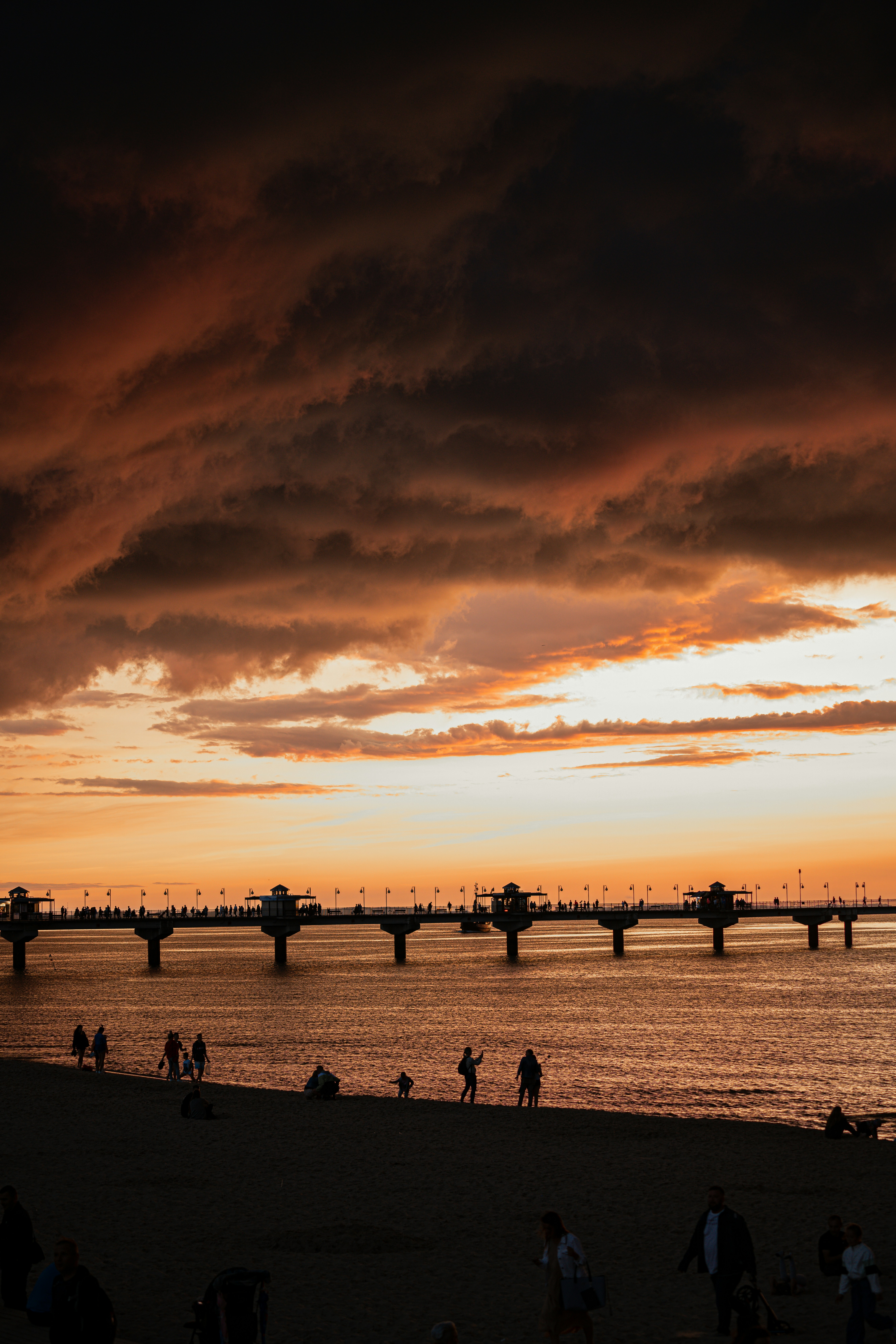 Horizon in Fire: Silhouetted Pier at the Edge of Evening Storm