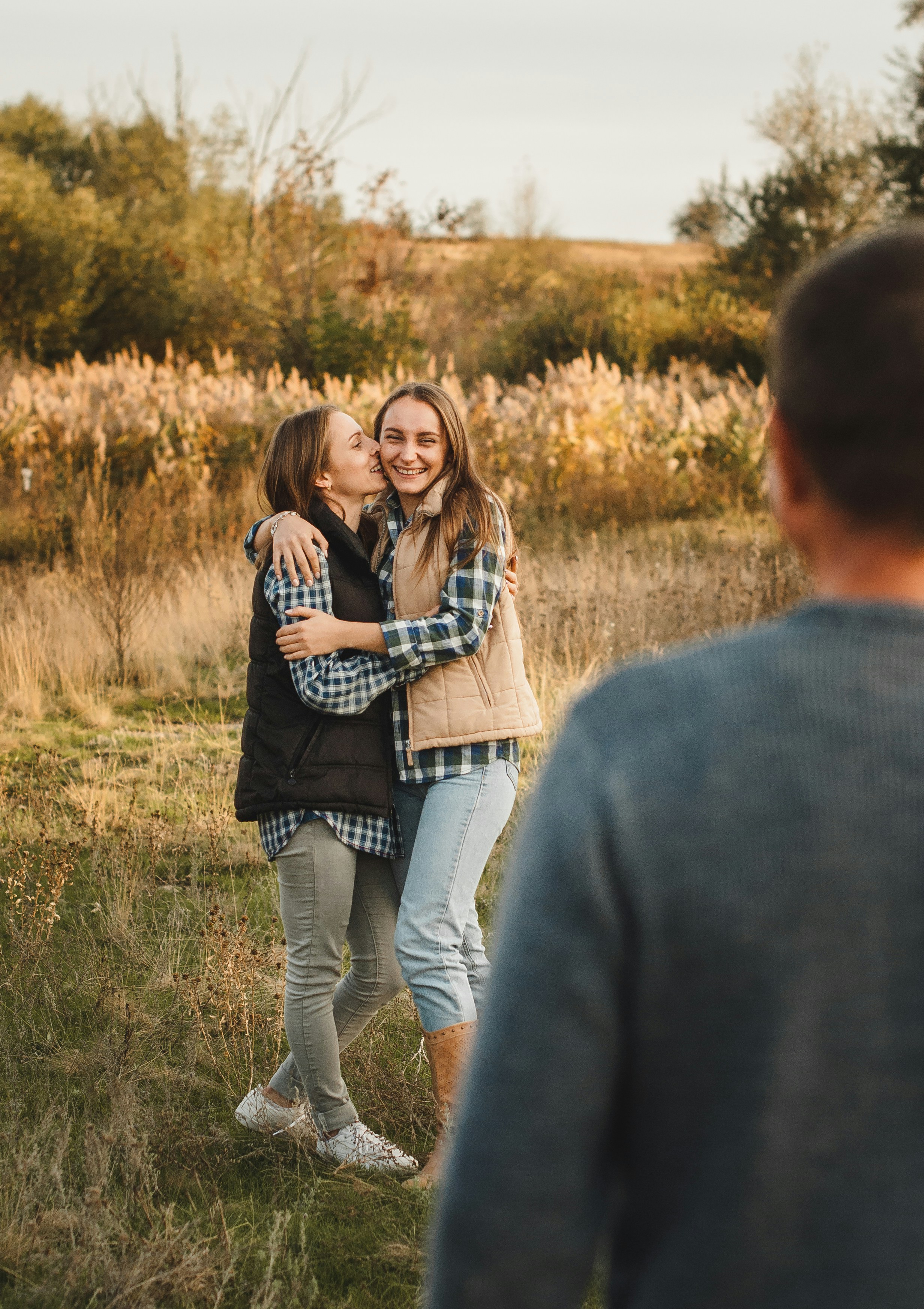 Man in gray sweater hugging woman in black and white checkered dress ...