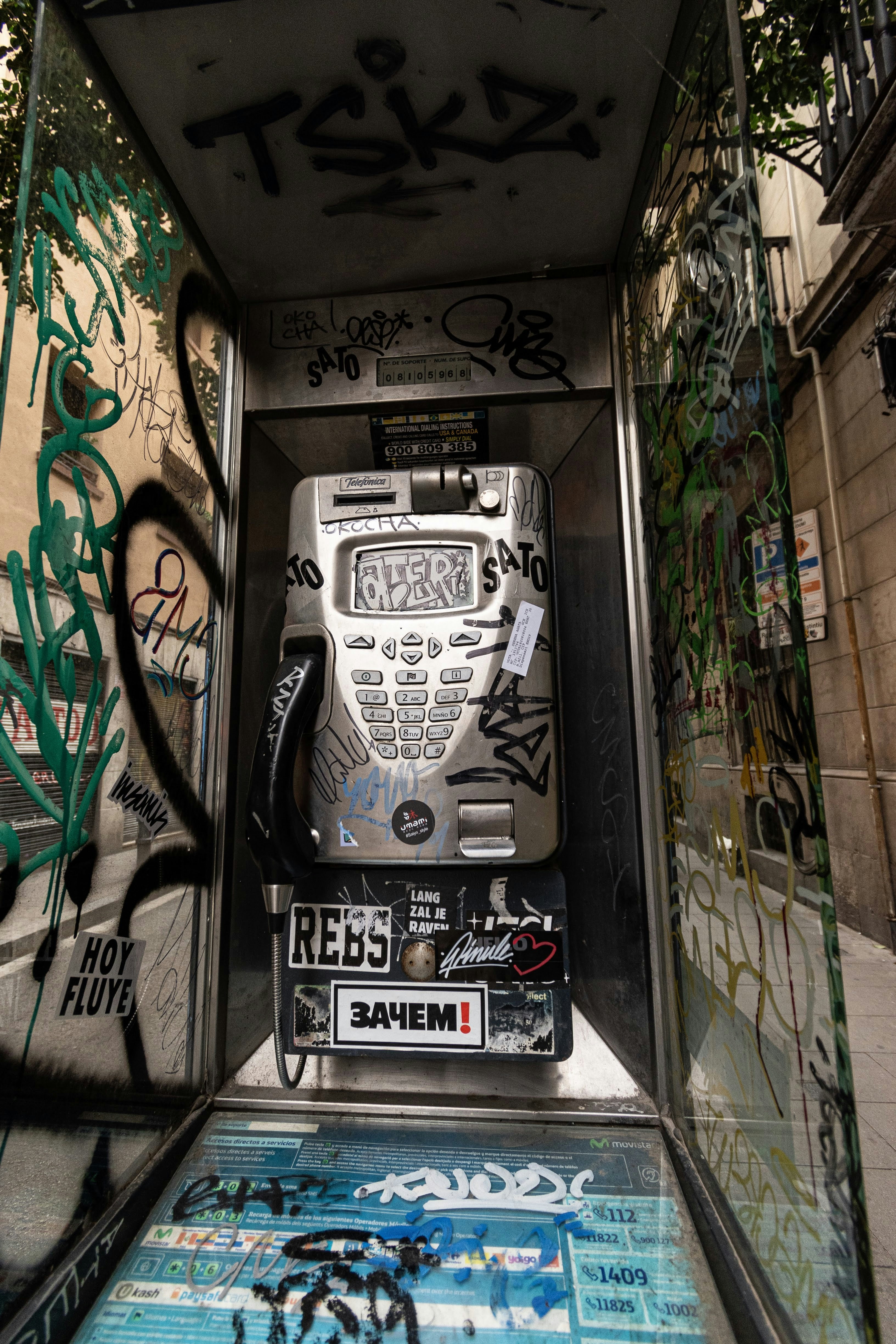 Graffiti-Stained Payphone in an Alley of Echoed Colors