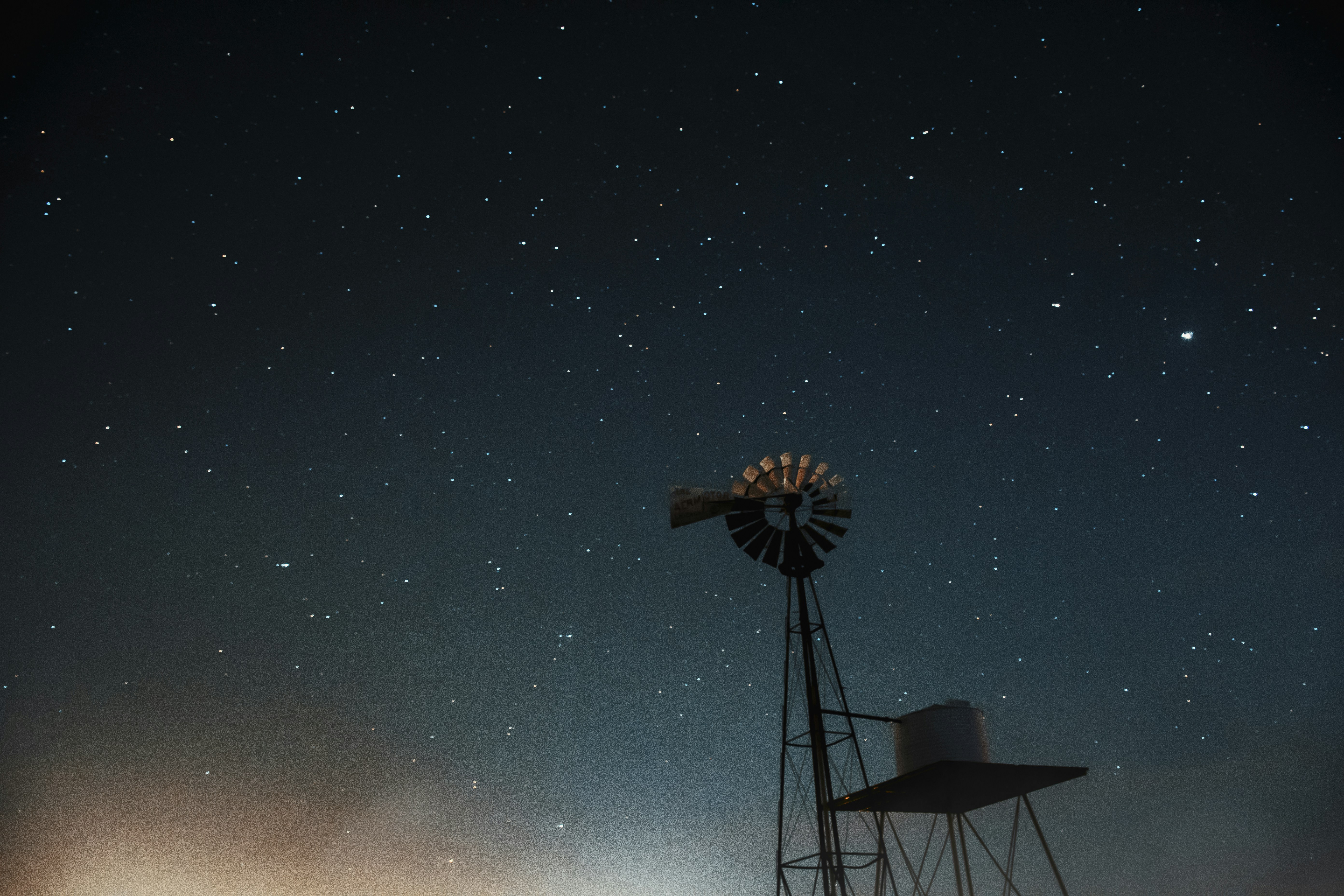 Windmill Silhouette in a Starscape over a Quiet Horizon