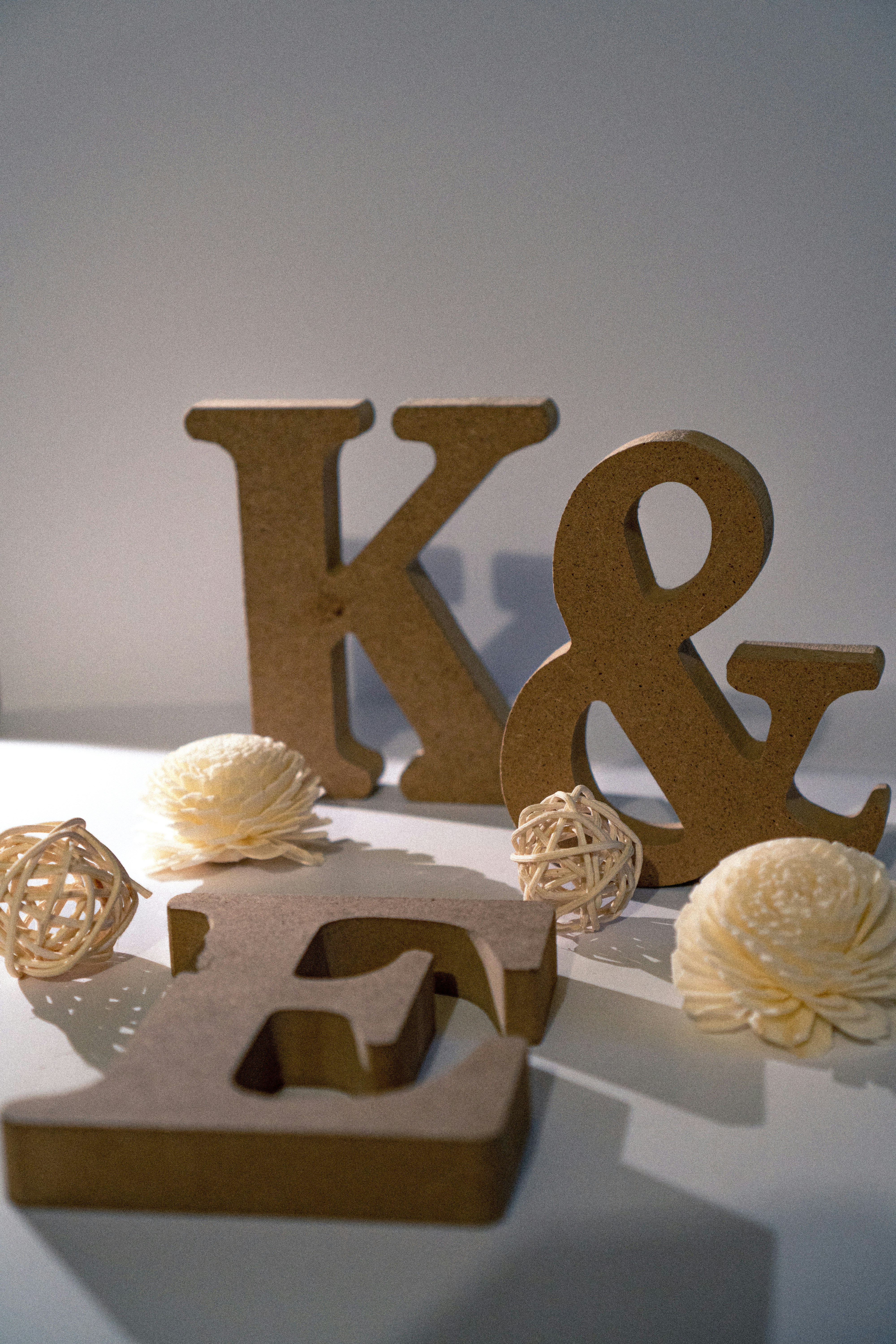 K & L in Warm Studio Light: A Quiet Wooden Letters Still-Life with Decorative Orbs