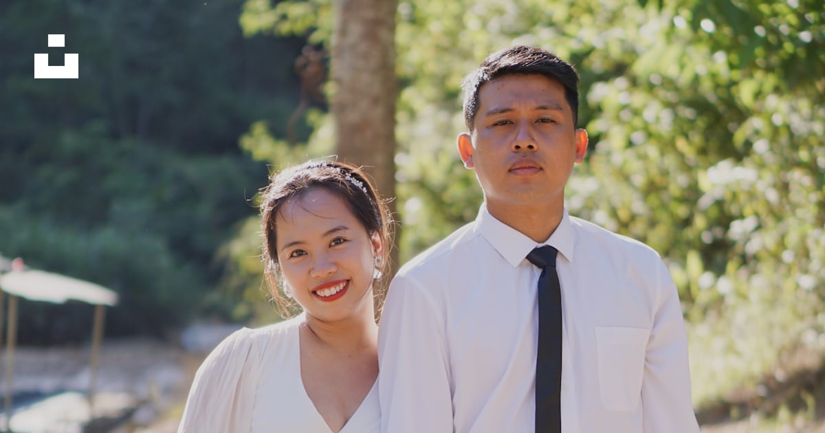 Man In White Dress Shirt And Black Pants Standing Beside Woman In White