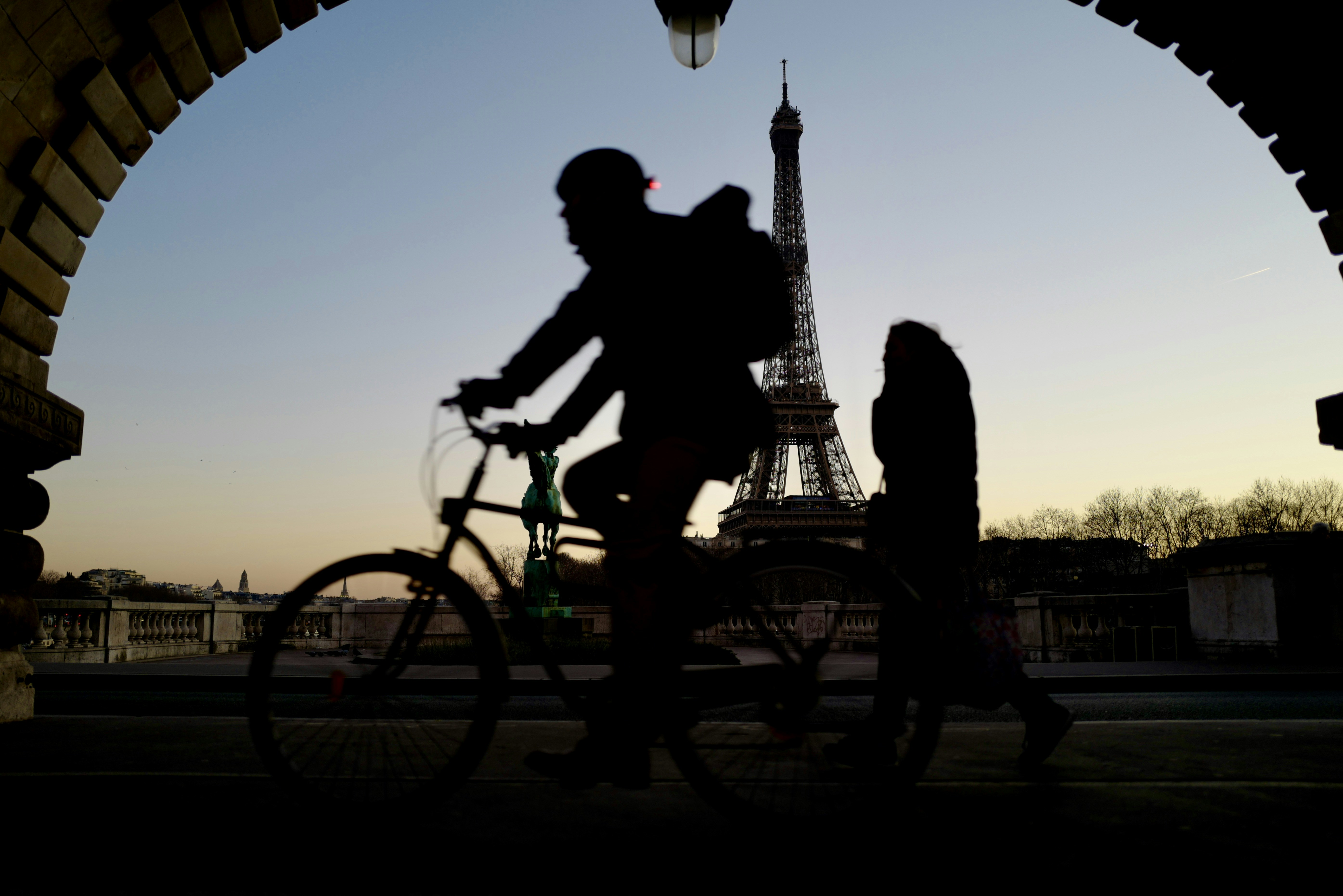 Archway Silhouettes: A Rider and a Stranger Framing the Eiffel Tower at Dusk