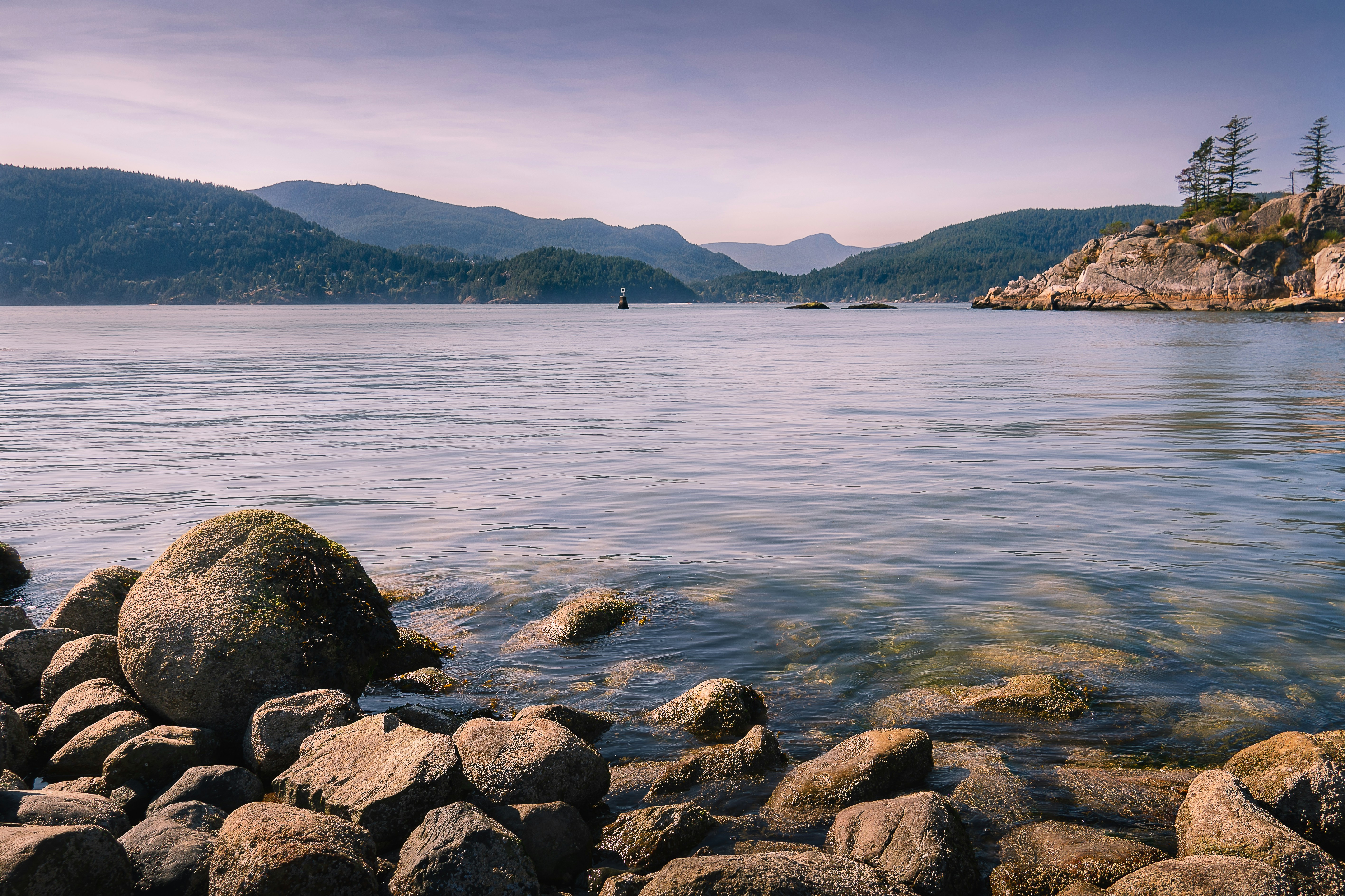 Peaceful rocky beach | brown rocks near body of water during daytime