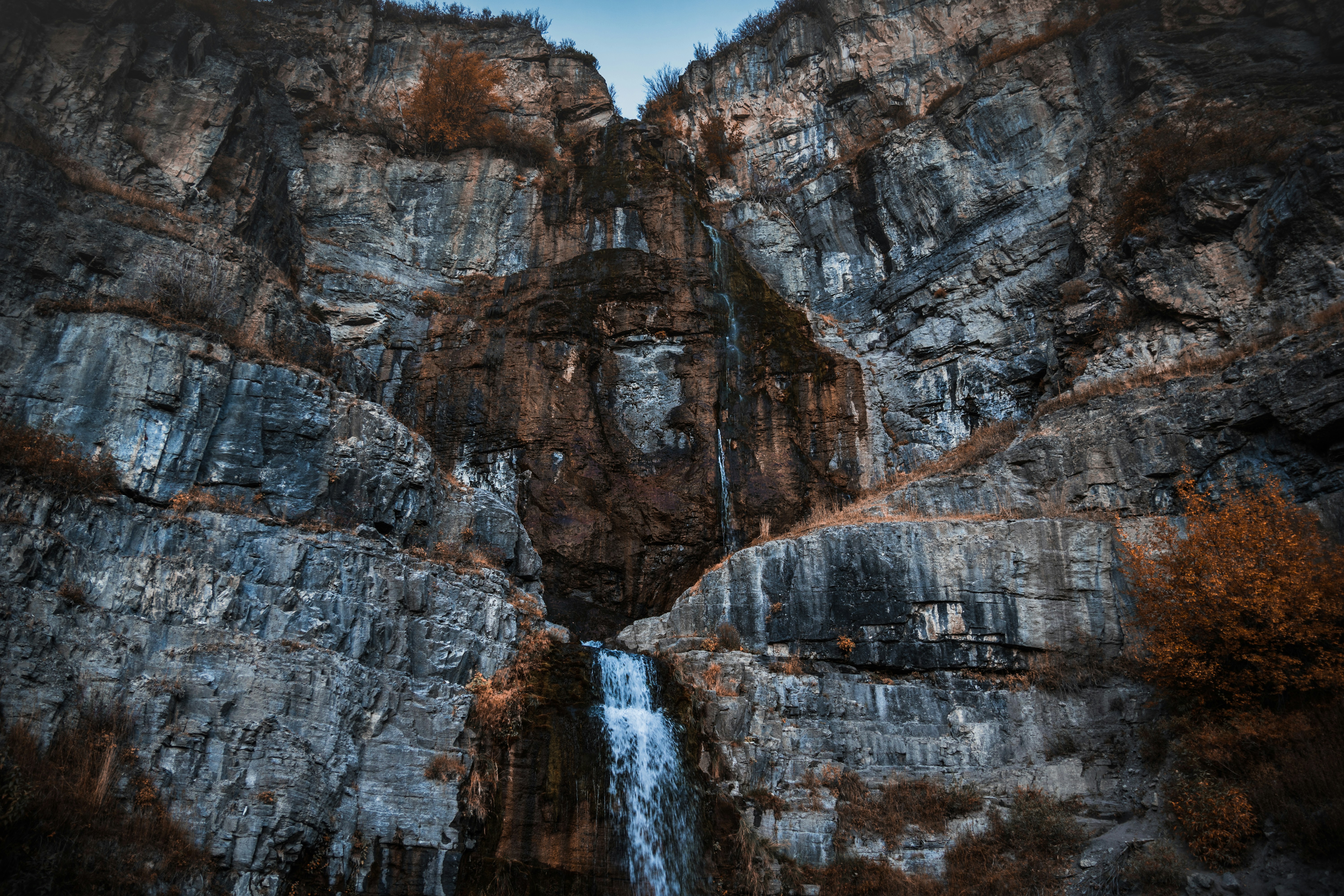 Cascading Veins: A Cliffside Cascade Between Weathered Strata