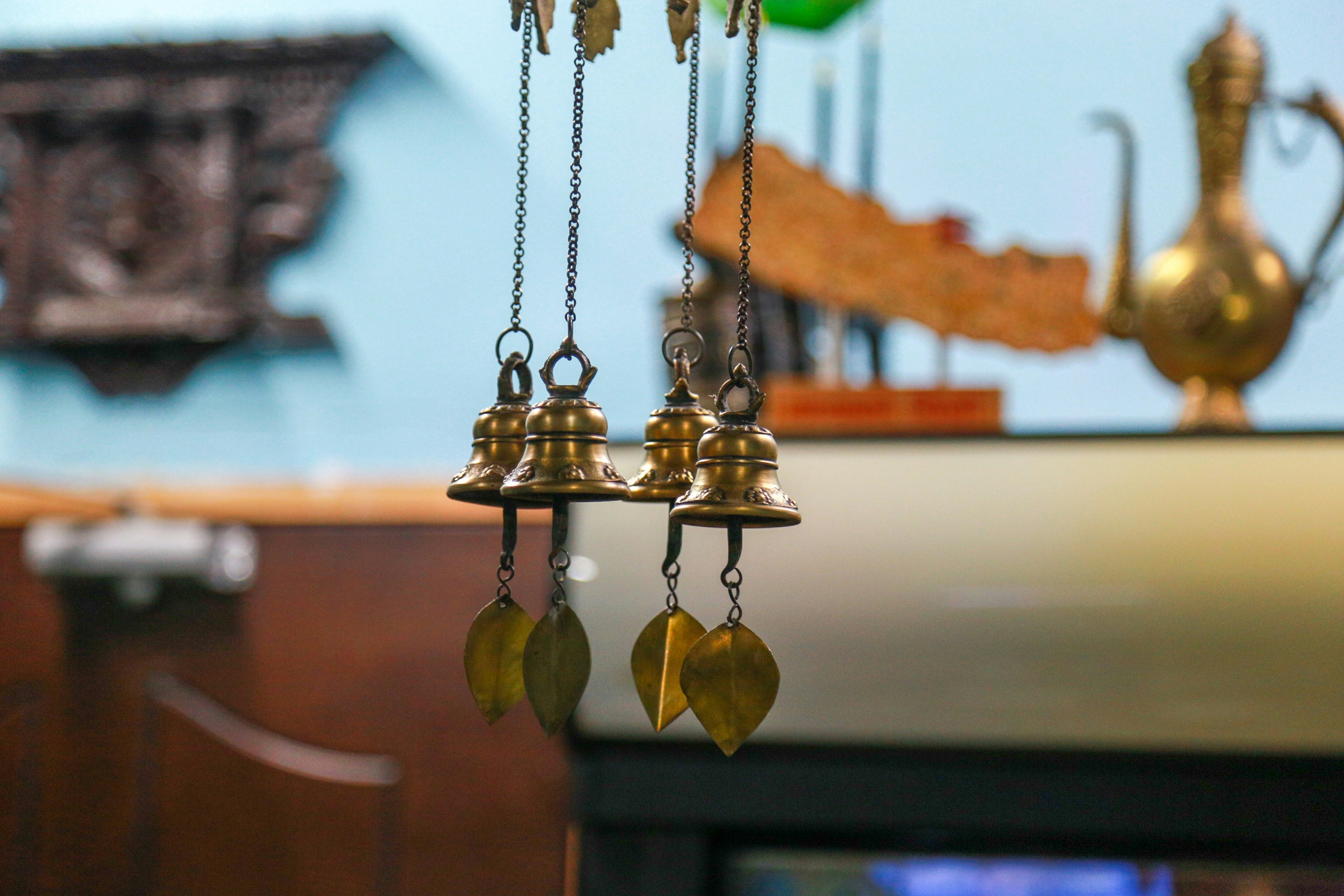 Suspended Brass Bells Against a Soft Temple Backdrop