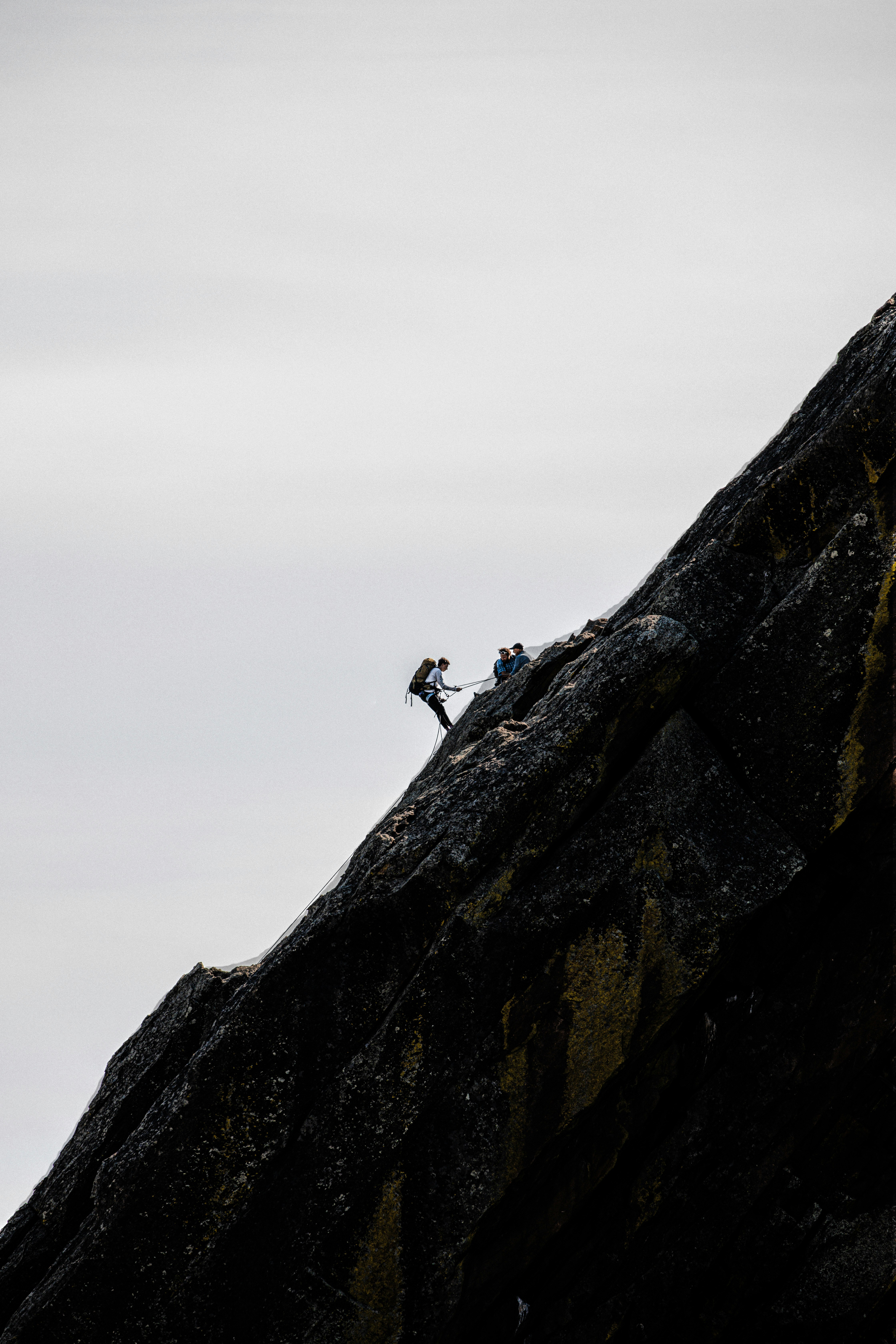 Climbers Traverse a sunlit Ridge: A Moment of Suspense on Narrow Granite