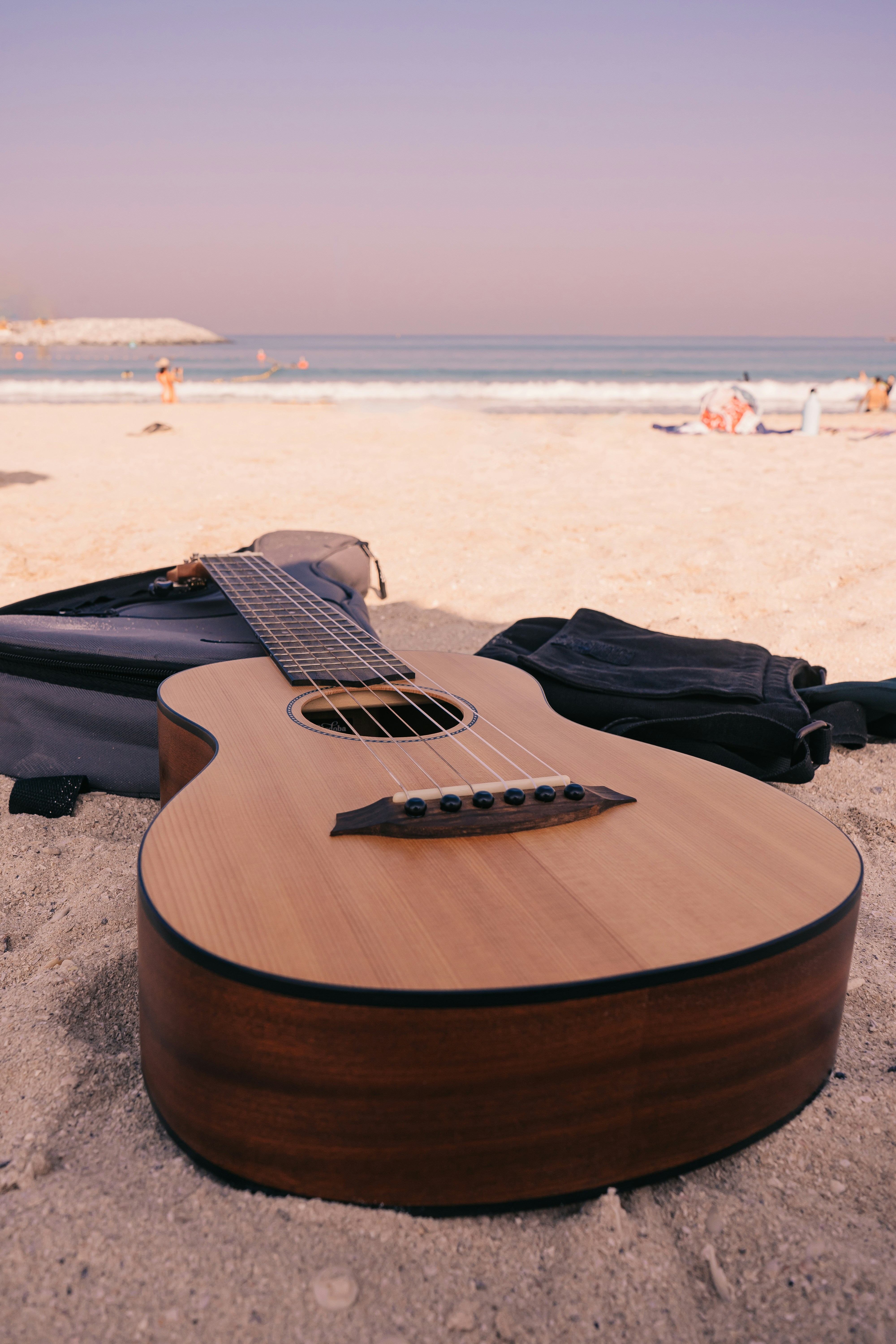 Beached Guitar Under a Pink Horizon: Warm Wood on Quiet Sand