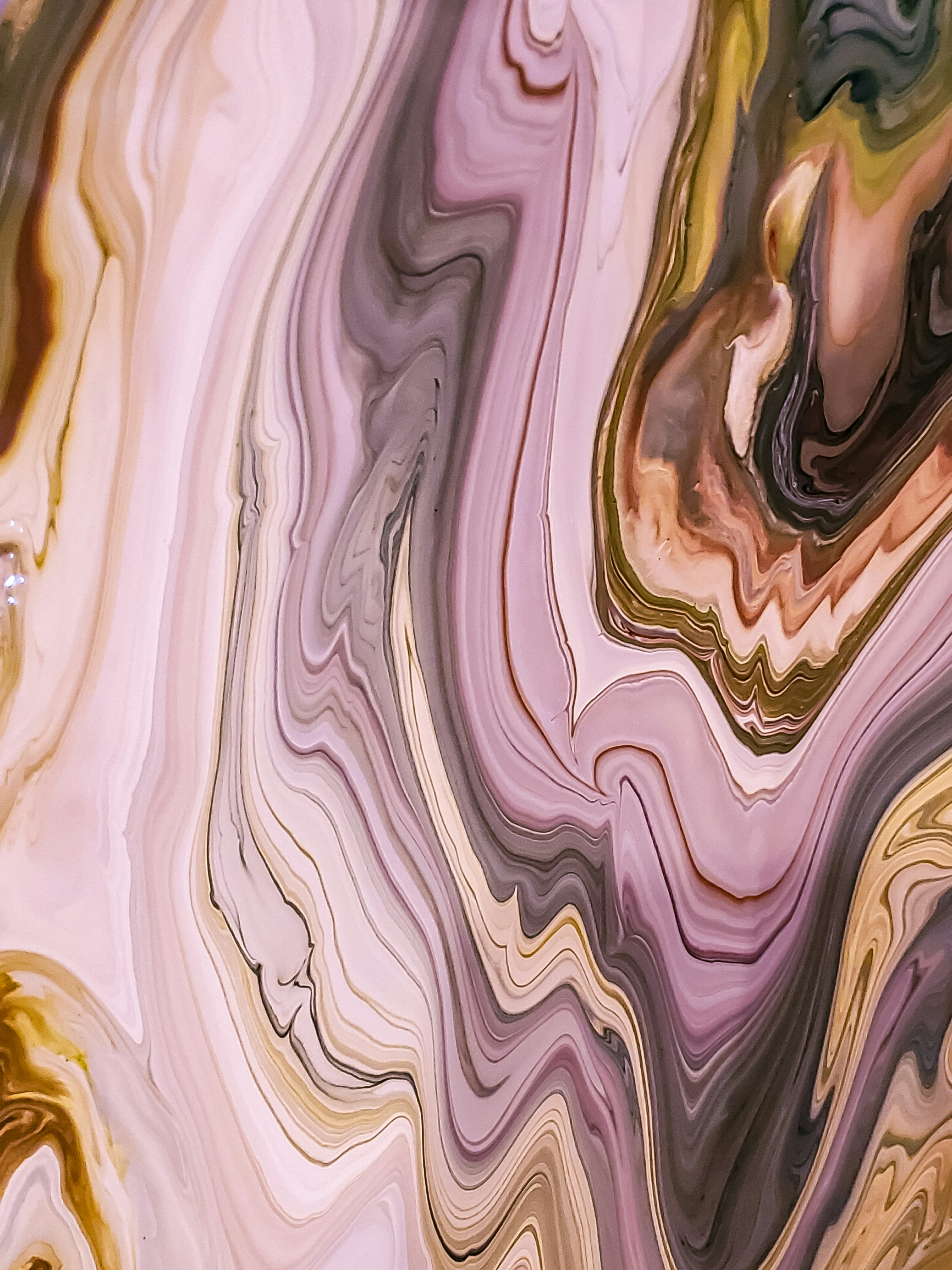 Abstract swirling patterns in shades of pink, purple, and gold create a mesmerizing visual effect. The artwork showcases the beauty of natural stone textures.