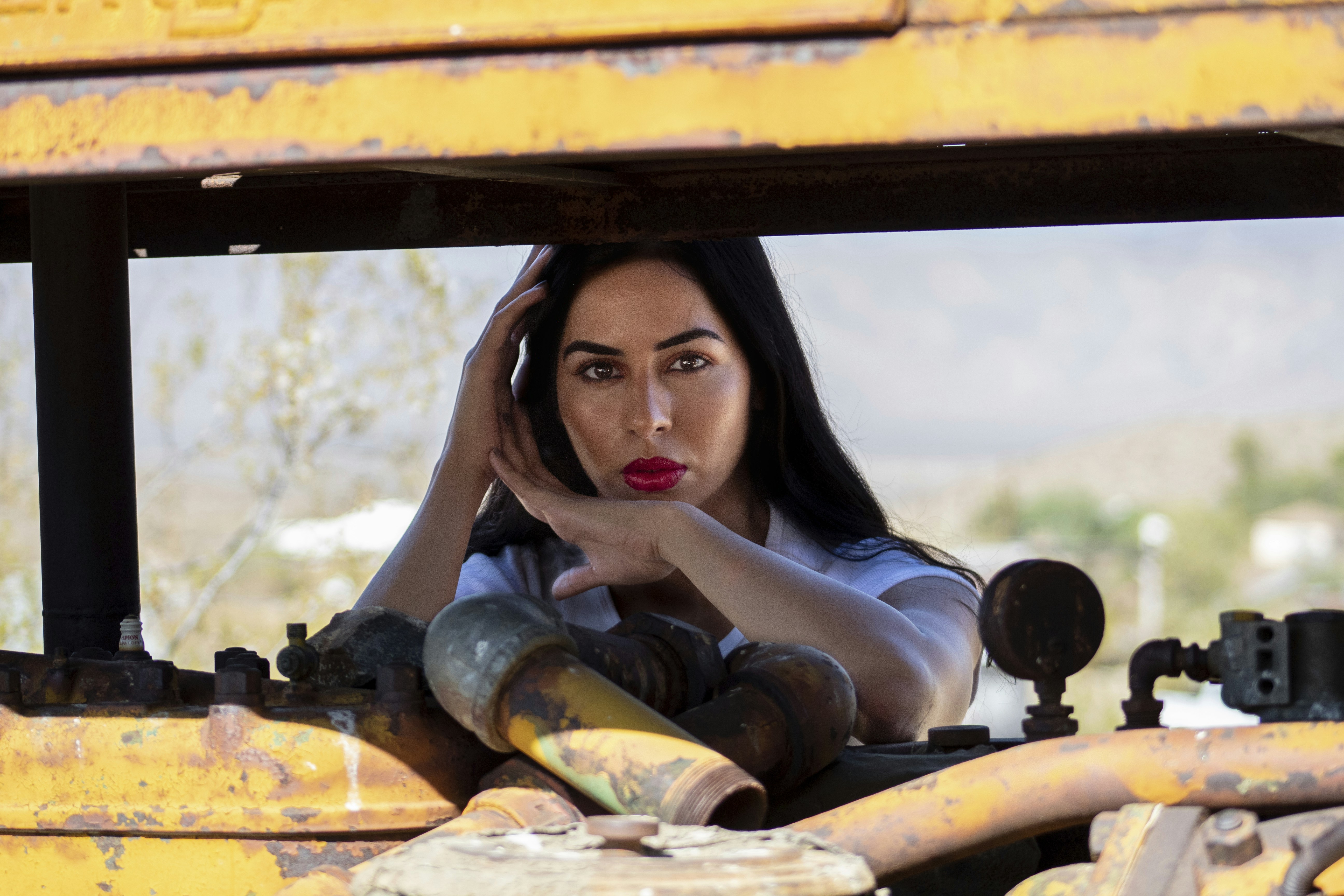 Hands framing the gaze: Portrait through rusted machinery