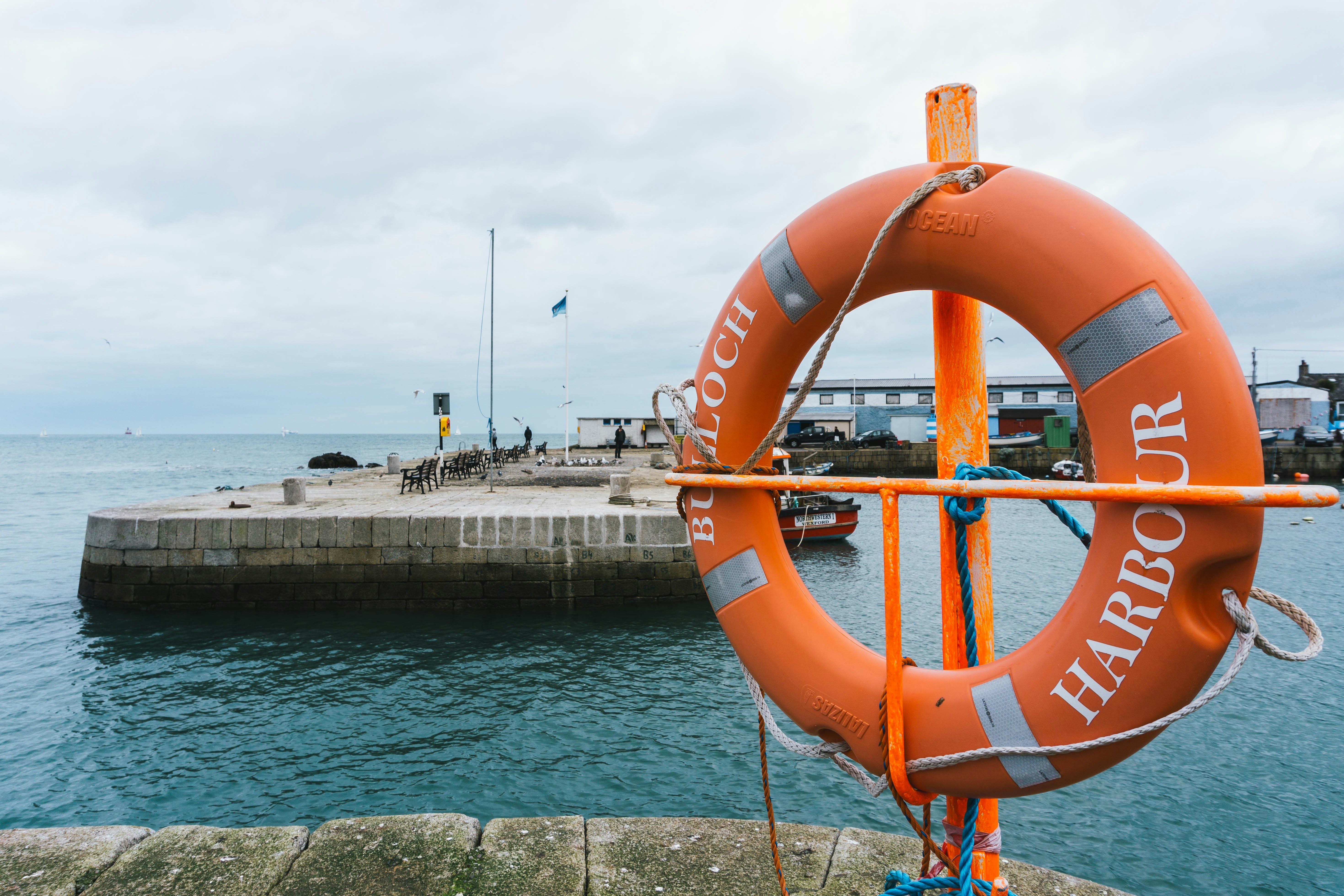 Orange Lifebuoy Framing a Quiet Harbour