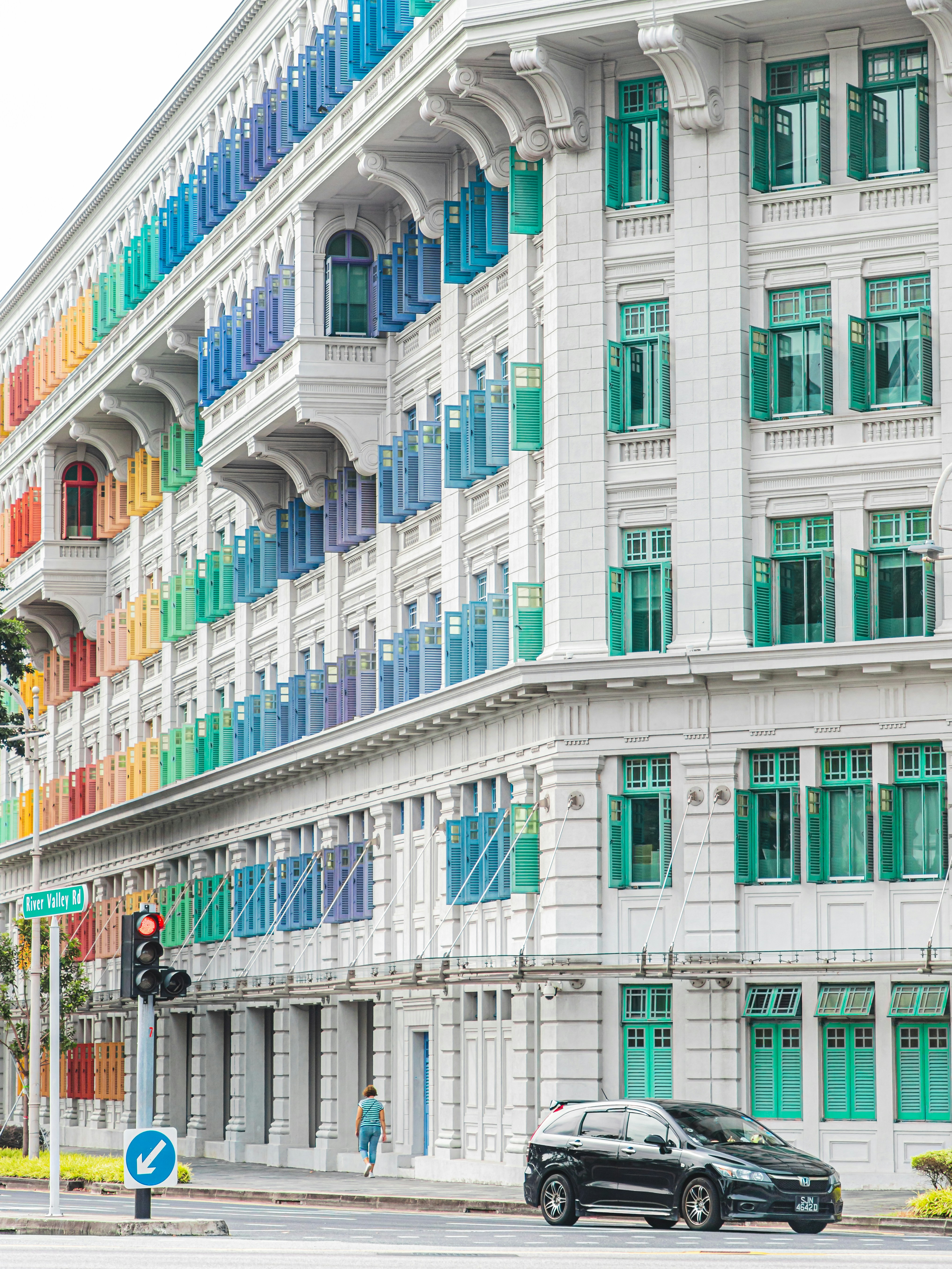 Chromatic Facade: Rainbow Windows on a White City Block