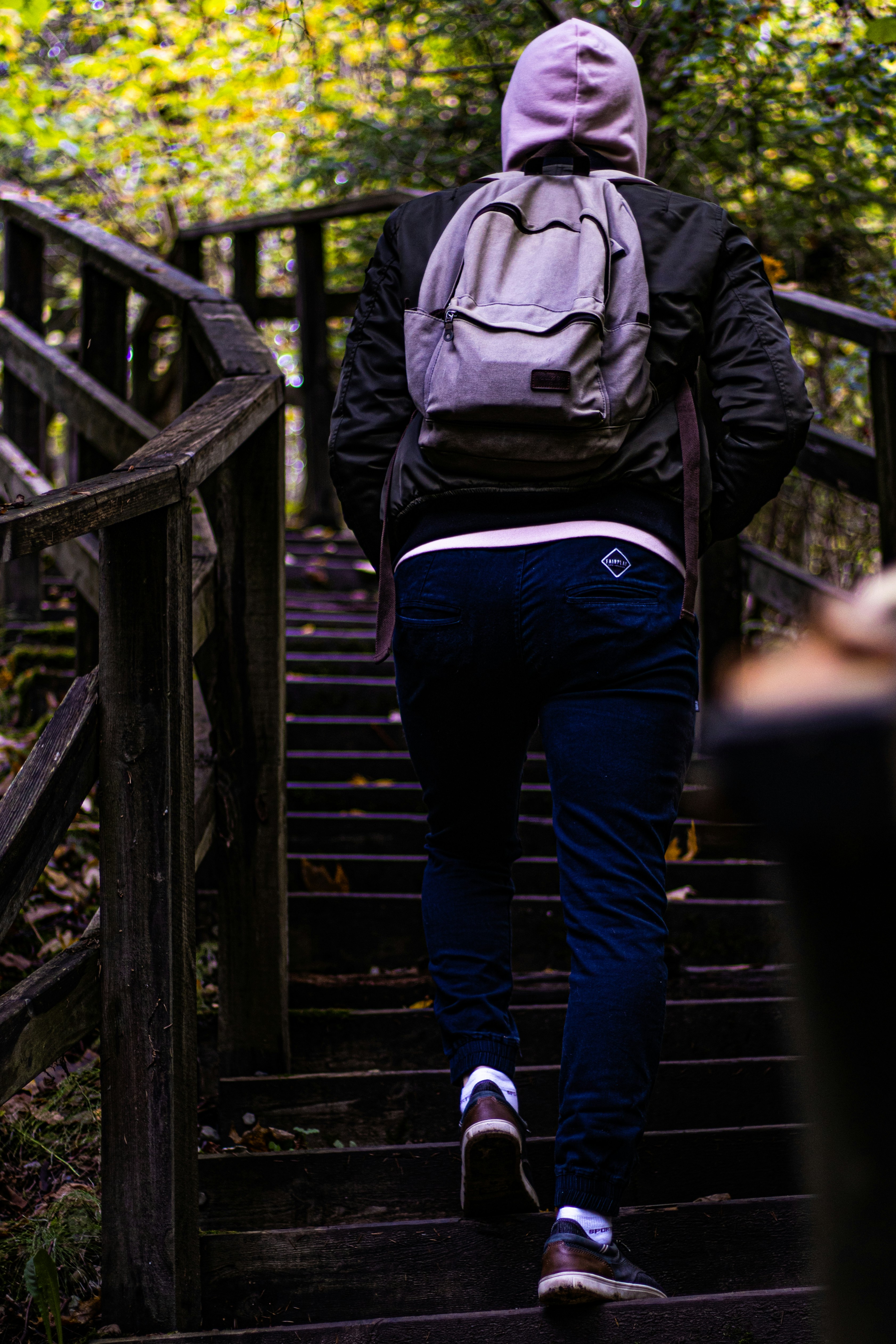 Foto Persona con chaqueta gris y jeans vaqueros azules de pie en un puente de madera – Imagen ...