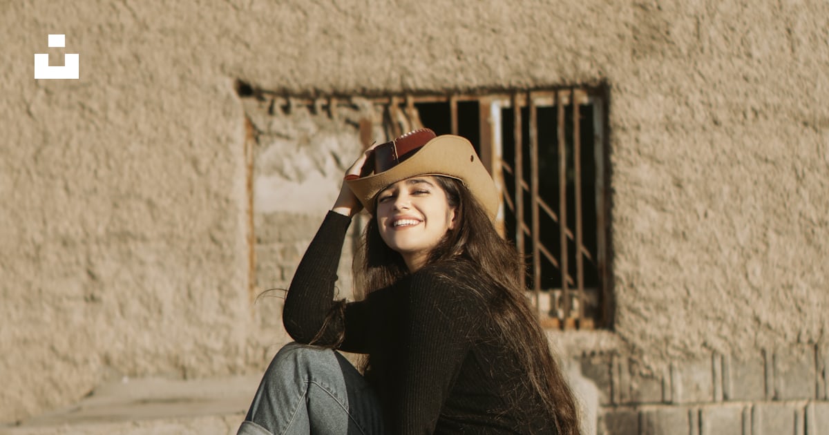 Frau In Braunem Hut Und Schwarzem Langarmhemd Und Blauer Jeans Sitzt