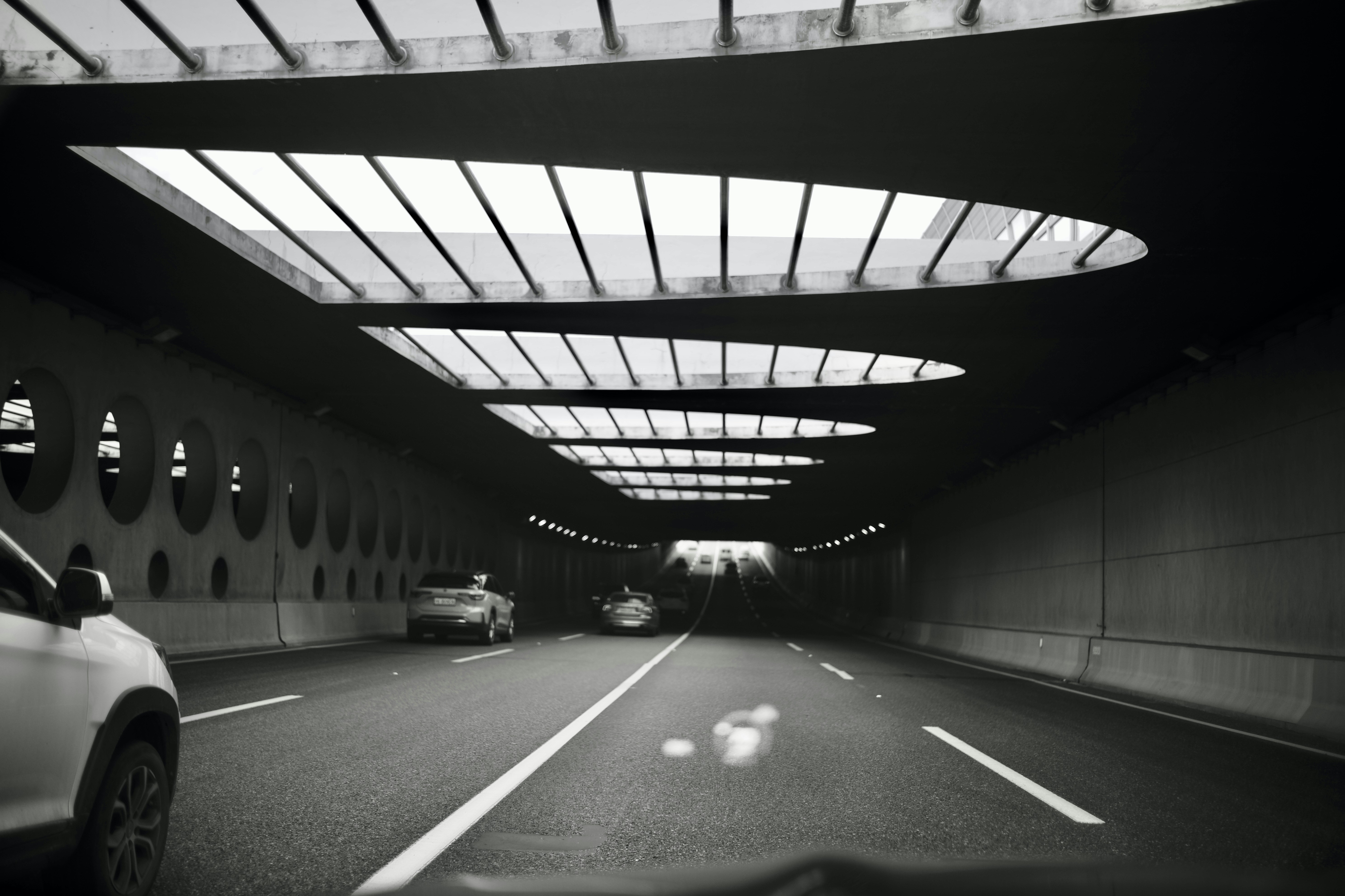 Ribbed Light Corridor: A Monochrome Drive Through an Elliptical Tunnel