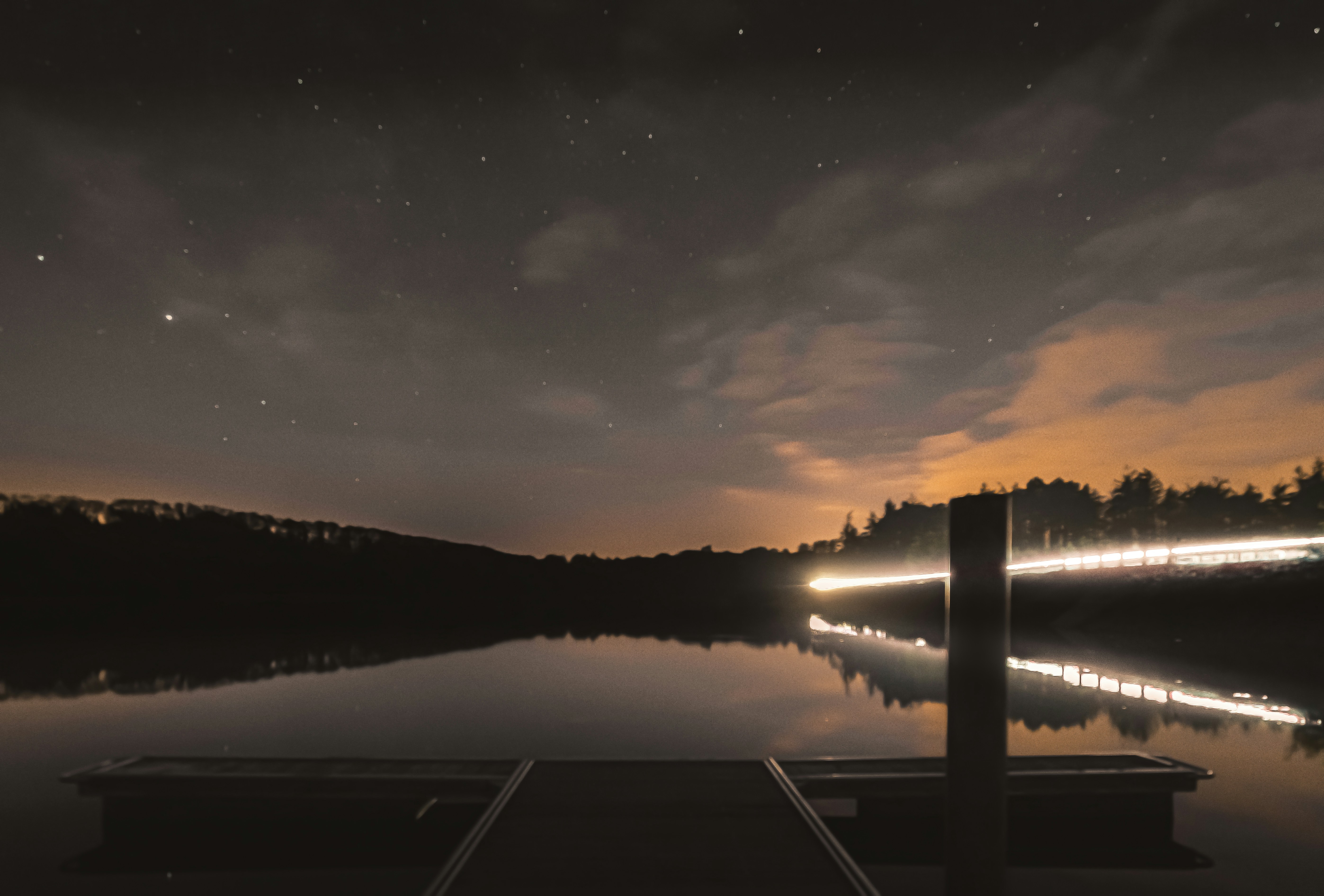 Luminous Jetty at Midnight: Reflections on a Glassy Lake