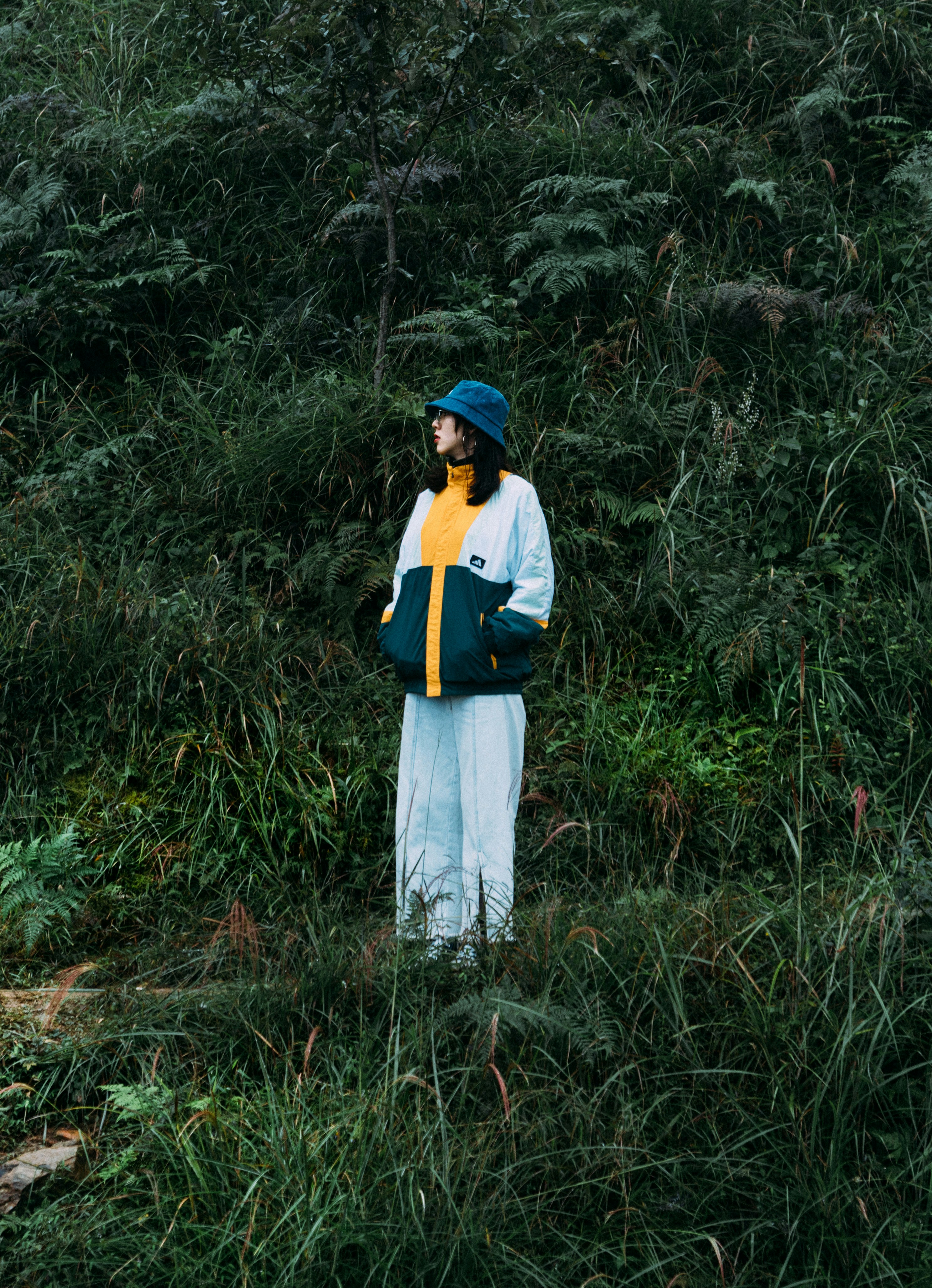 Neon Thread in the Green: A Lone Figure Amid Wild Grass