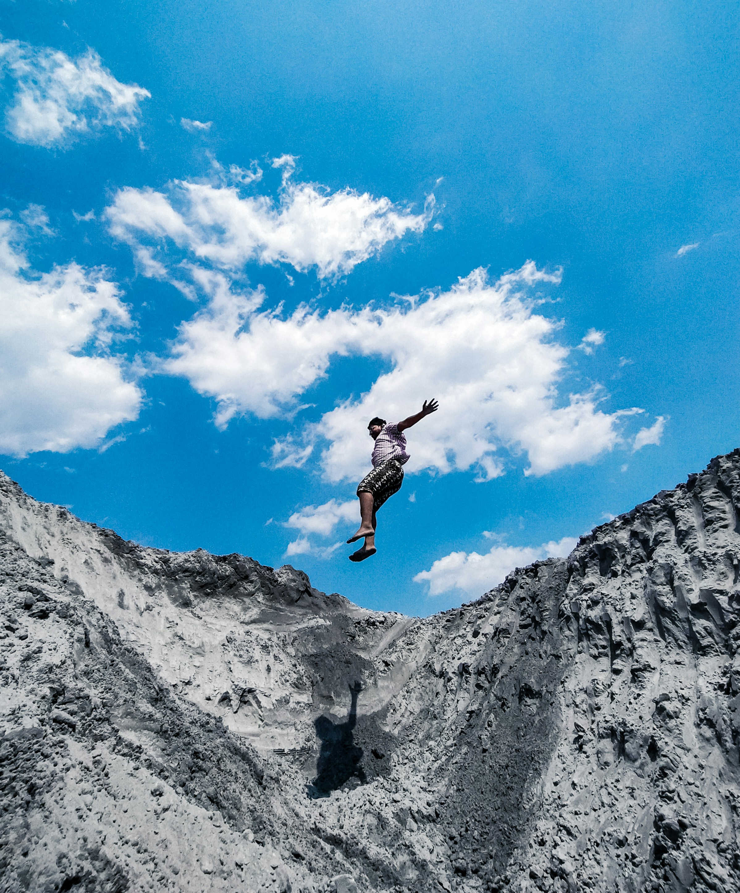 Midair Leap Over a Granite Ridge Beneath a Bright Blue Sky