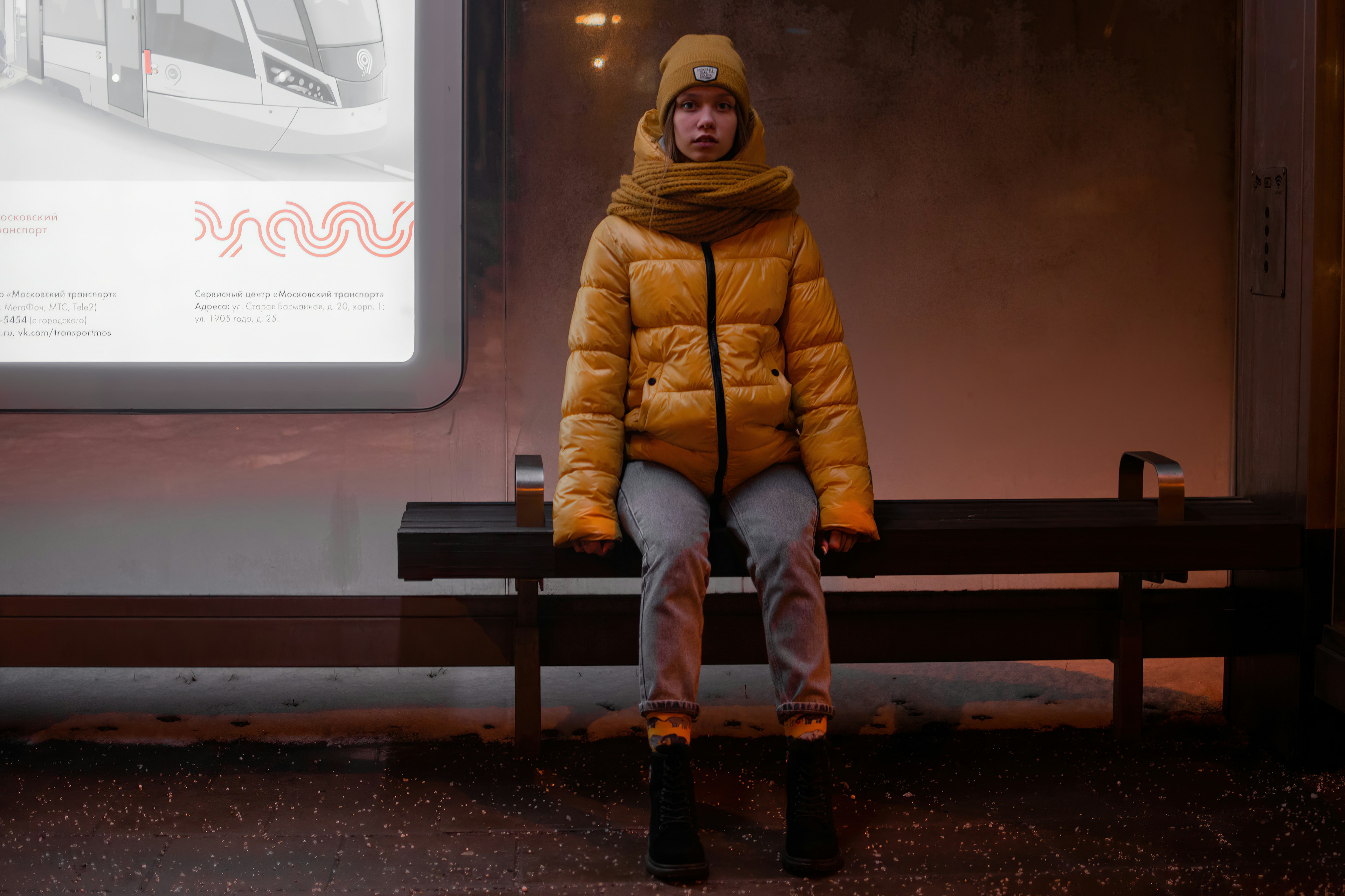 man in brown jacket sitting on bench