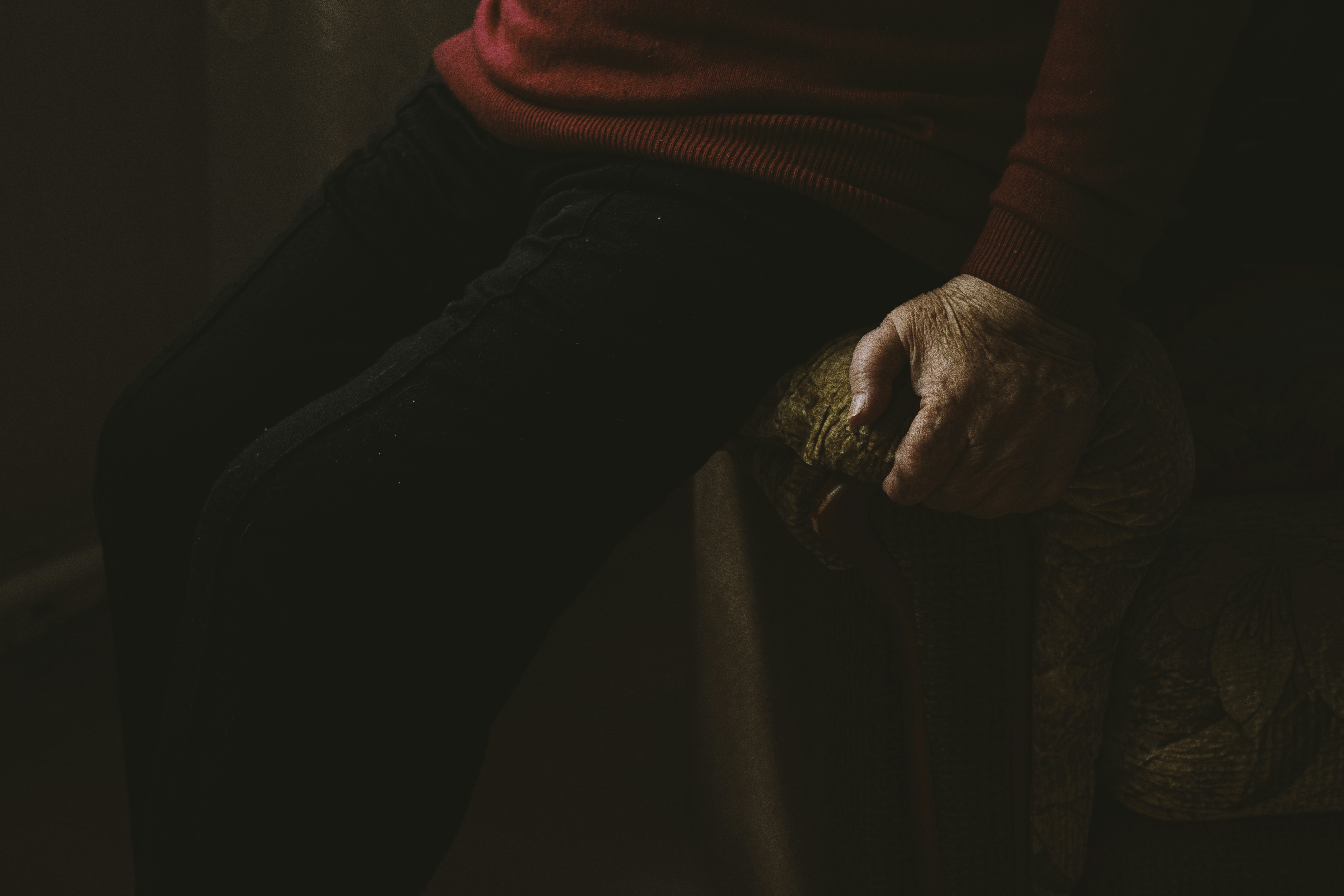 person in red sweater holding mans hand
