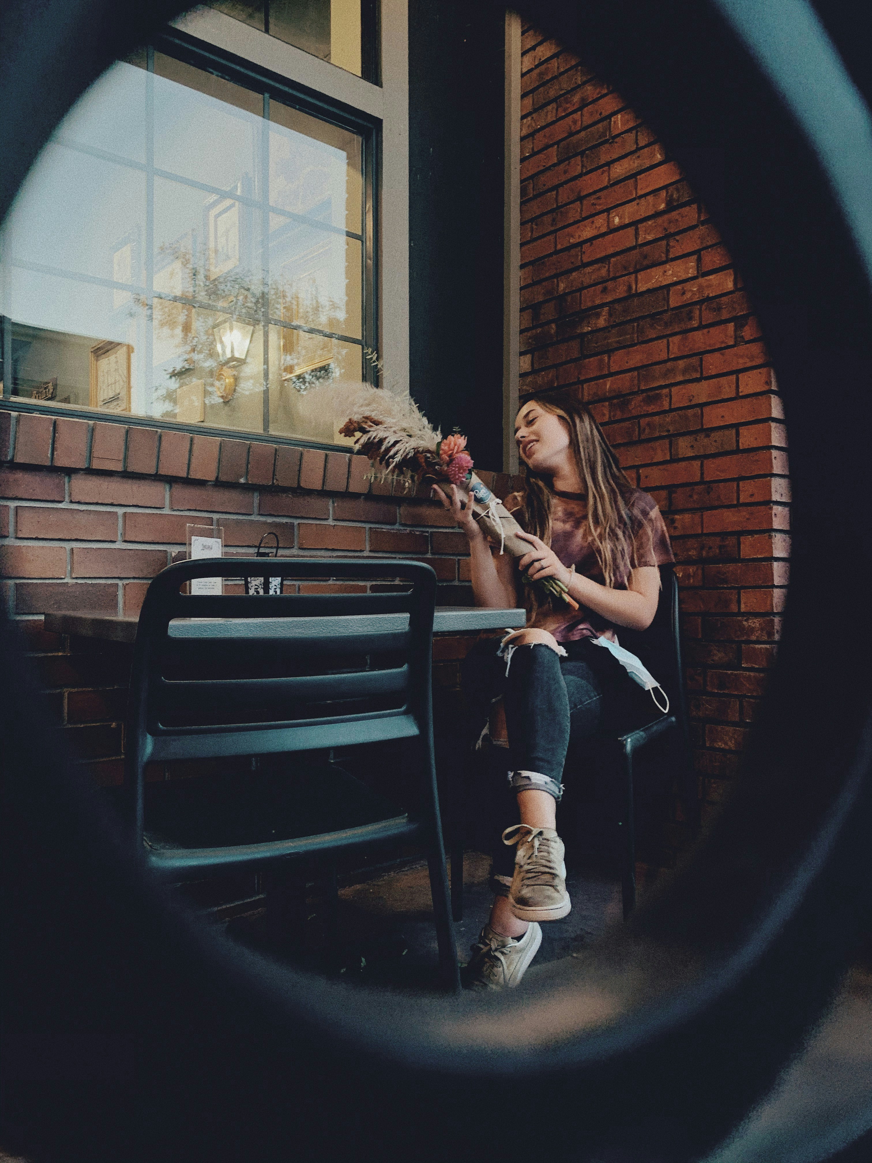 Bouquet at Brick-Walled Café: A Quiet Portrait Framed by a Circular Ring