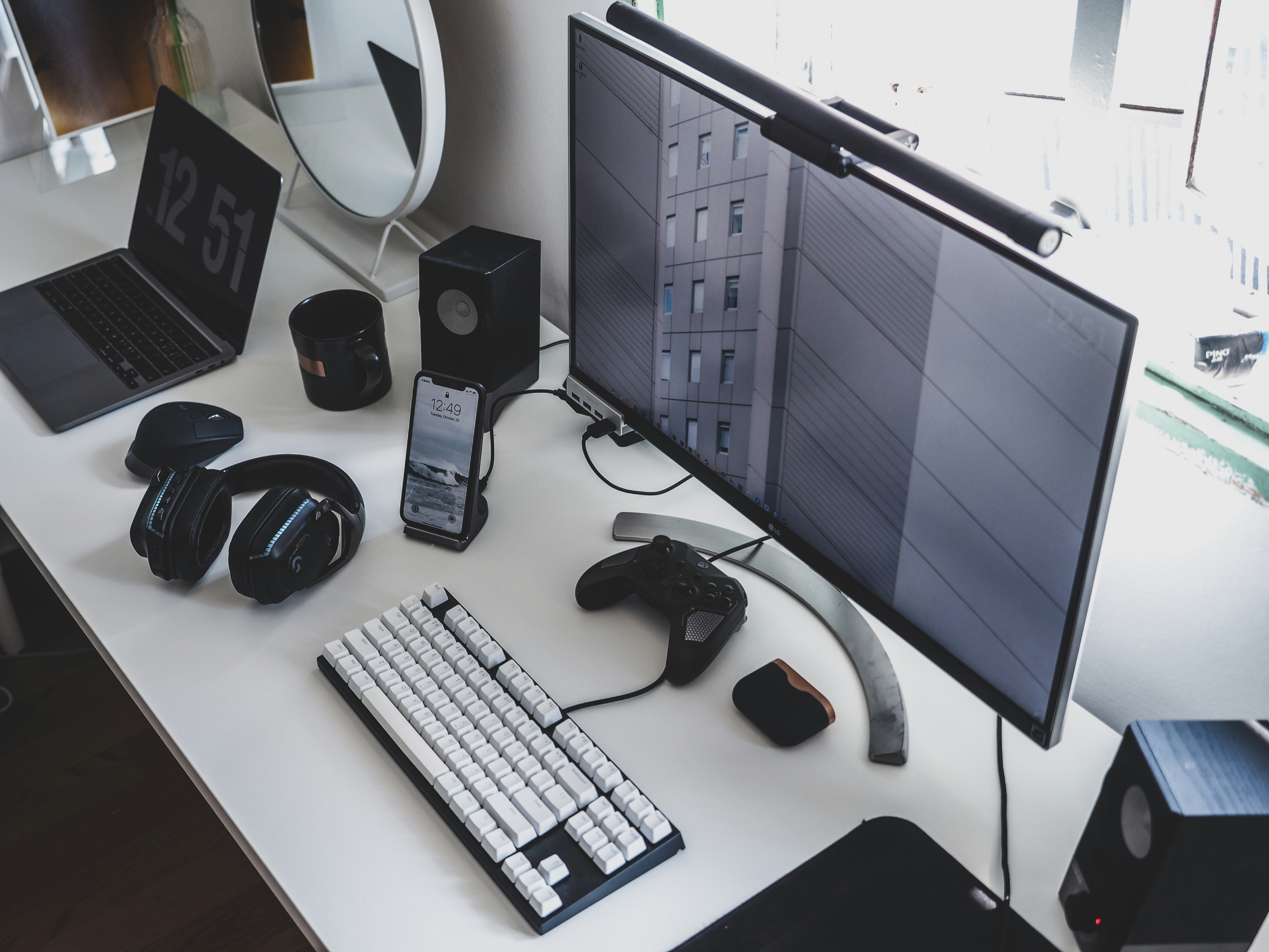 Black flat screen computer monitor and keyboard on white wooden desk ...