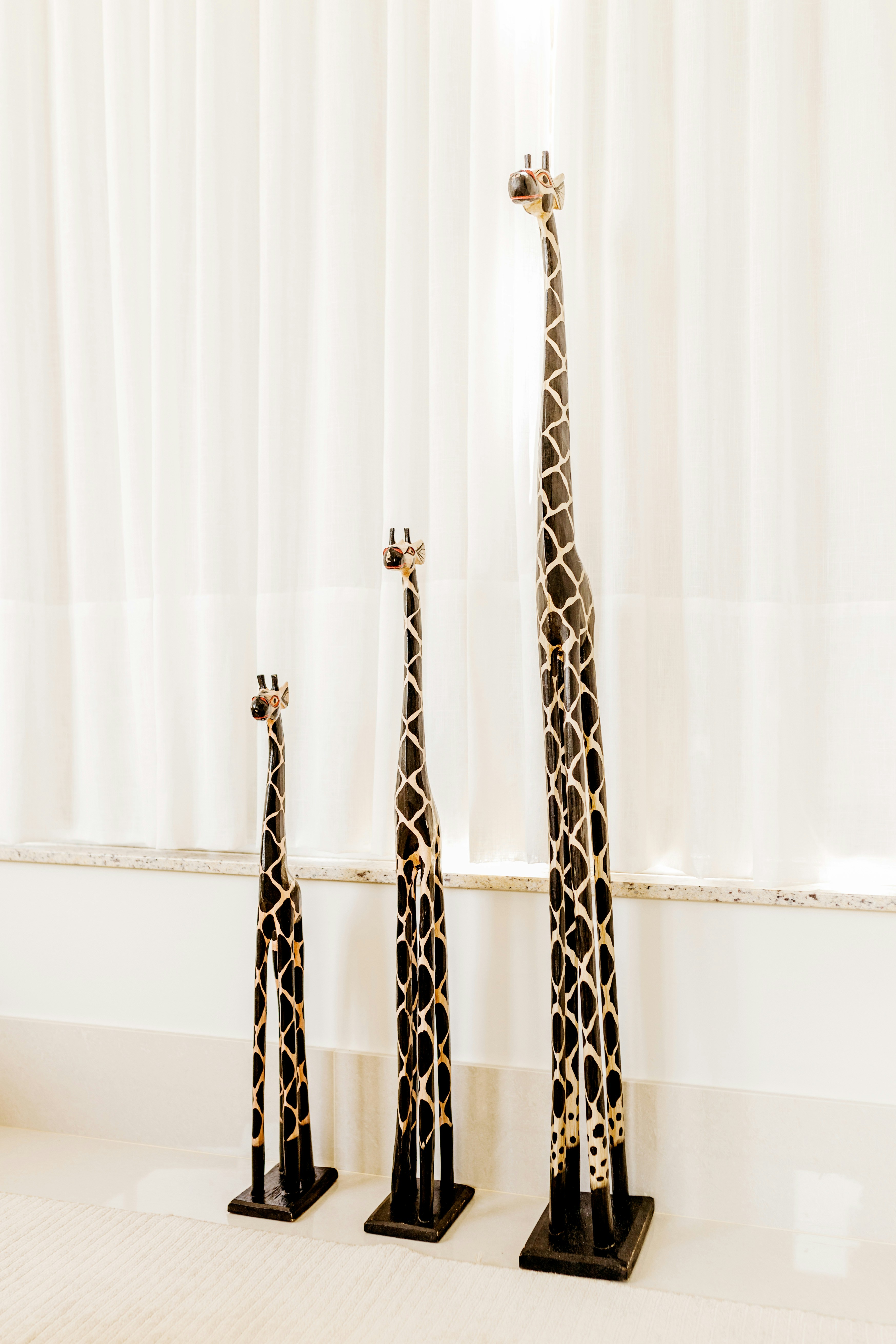Giraffes in Shadowless White: A Trio of Neon-Skinned Elegance
