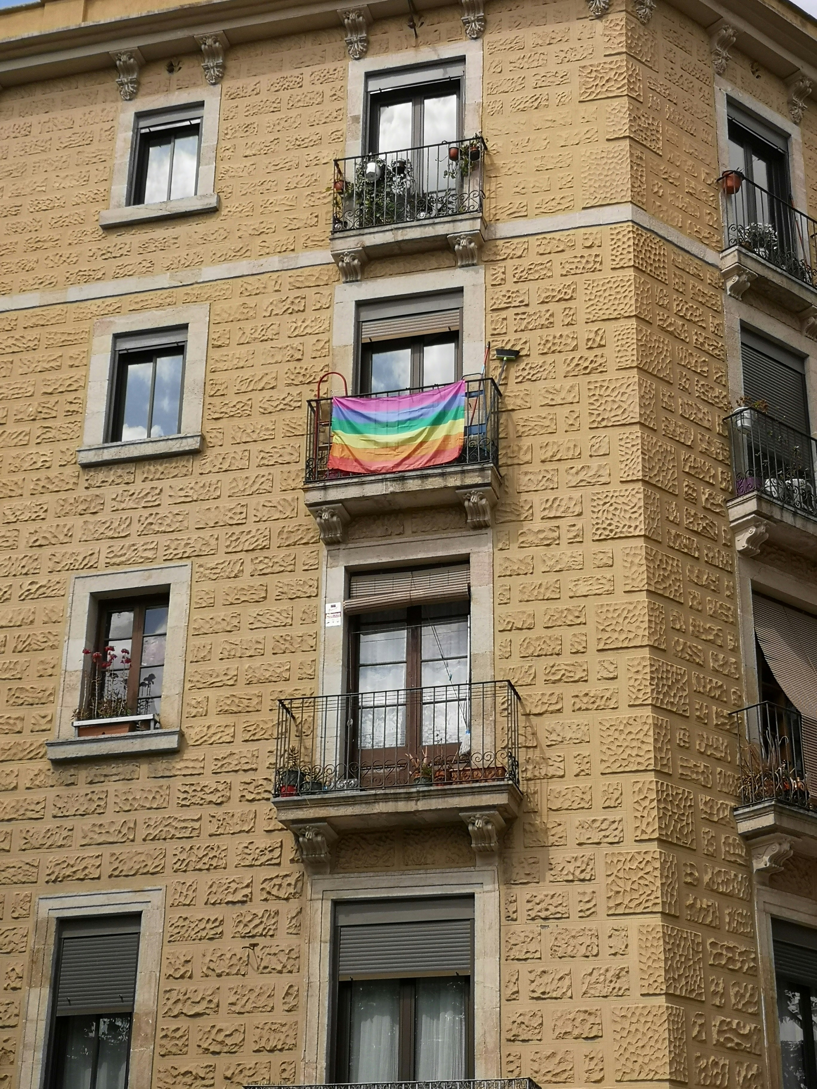 Rainbow Flag Draped Over Balcony of Historic Facade