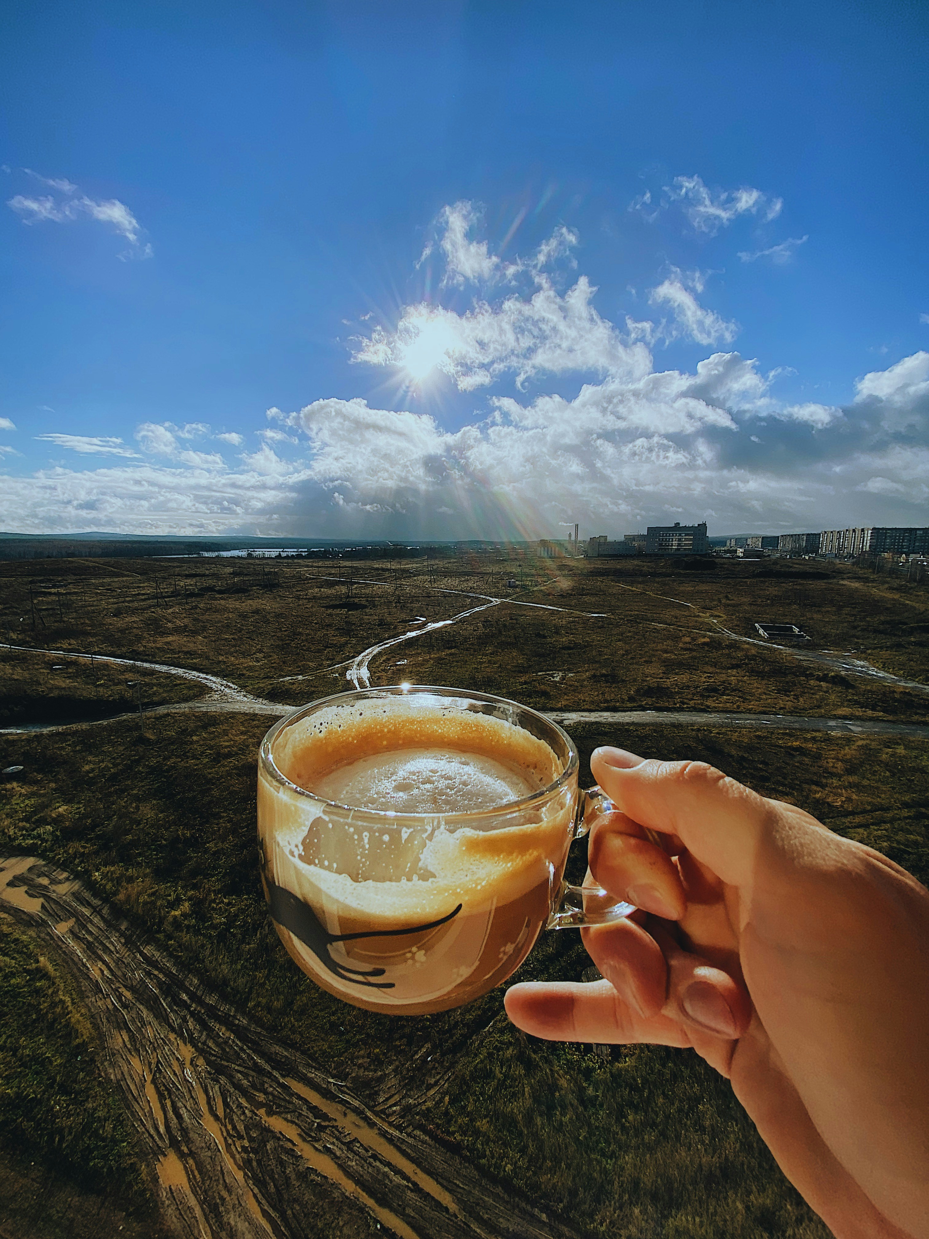 Dawn Brew in Hand: A Coffee Cup Framing a Winding Horizon