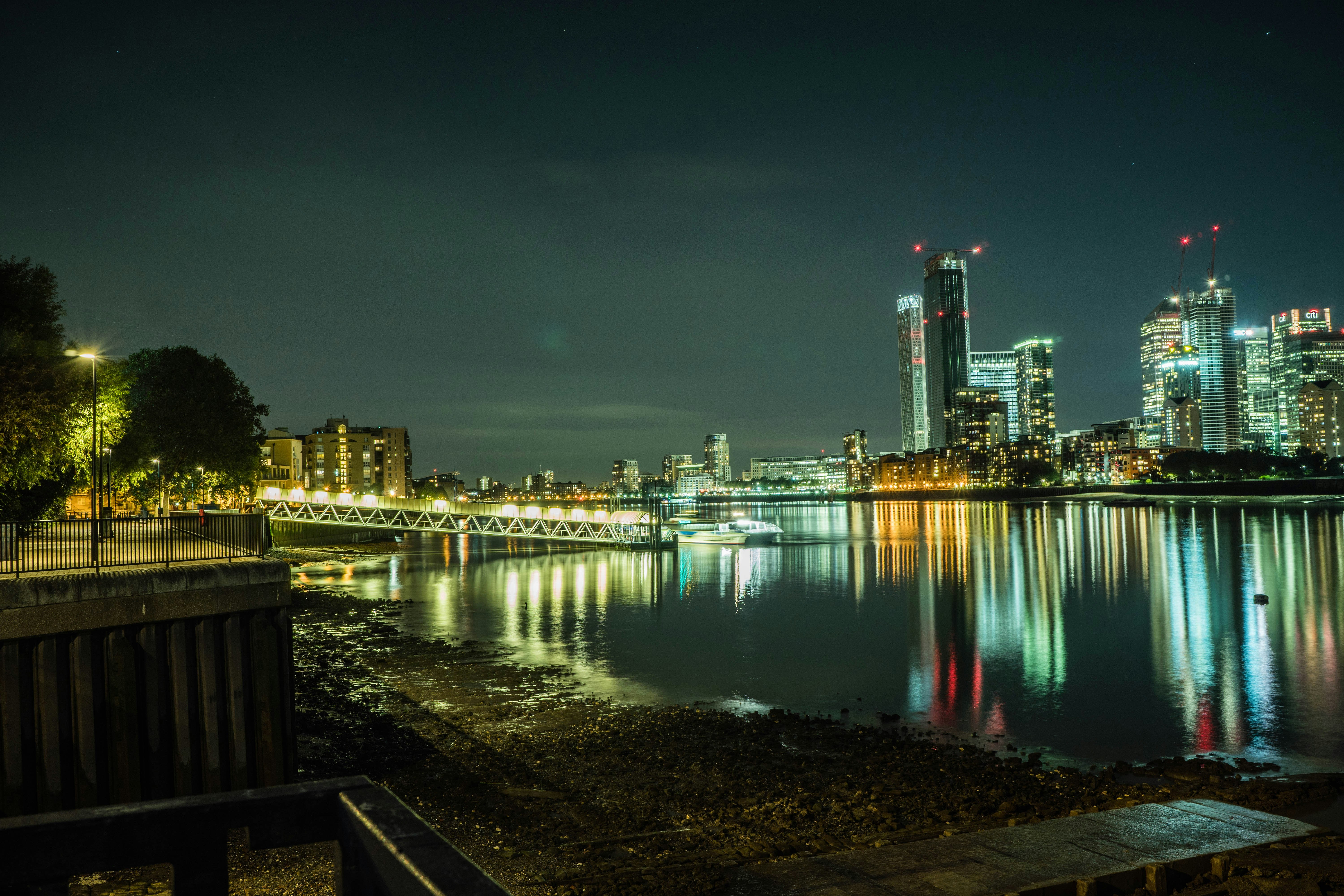 City skyline and bridge lights reflecting on the river at night.