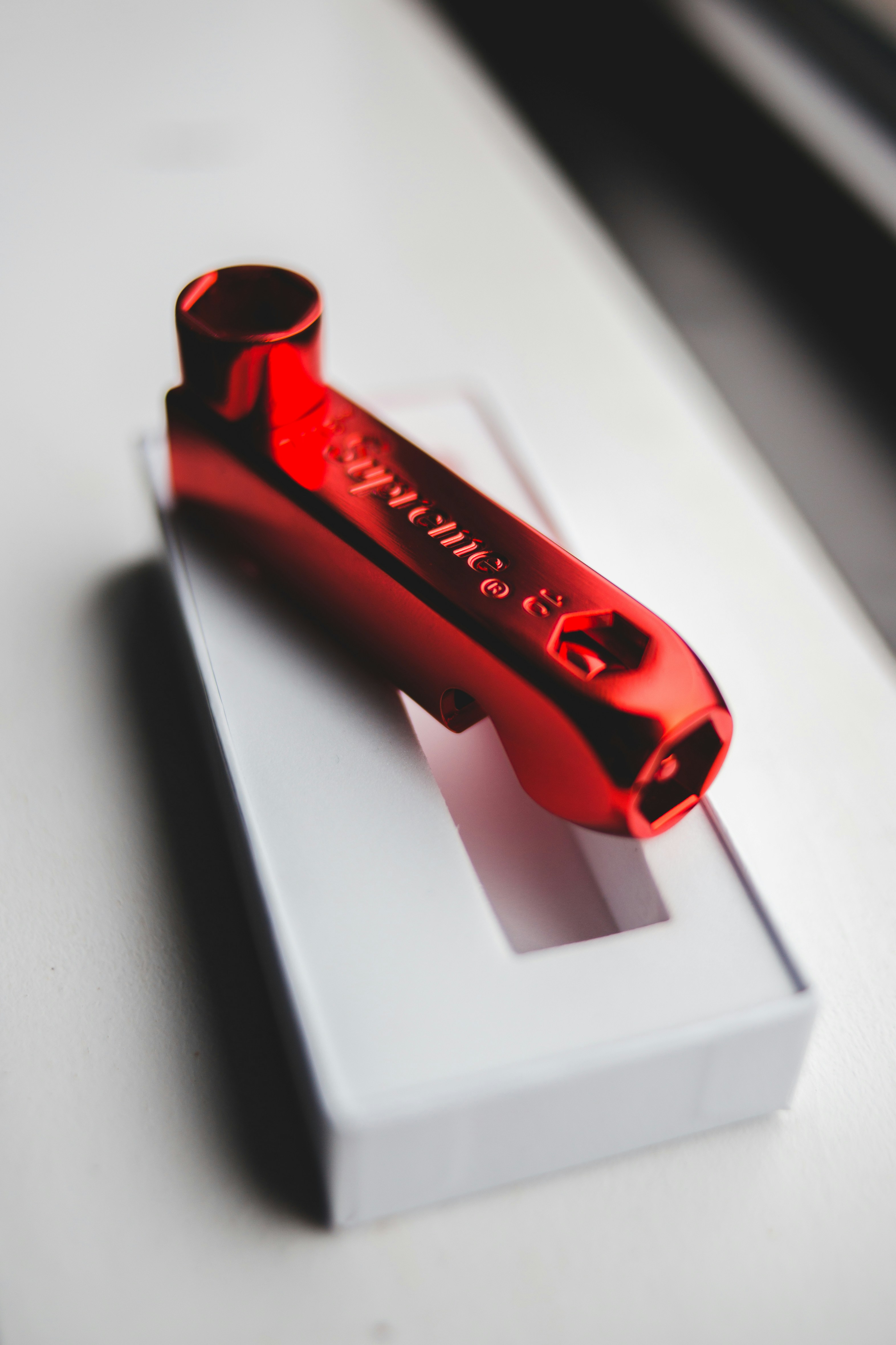Crimson Latch: a close-up on a red metal USB dongle resting in a white tray