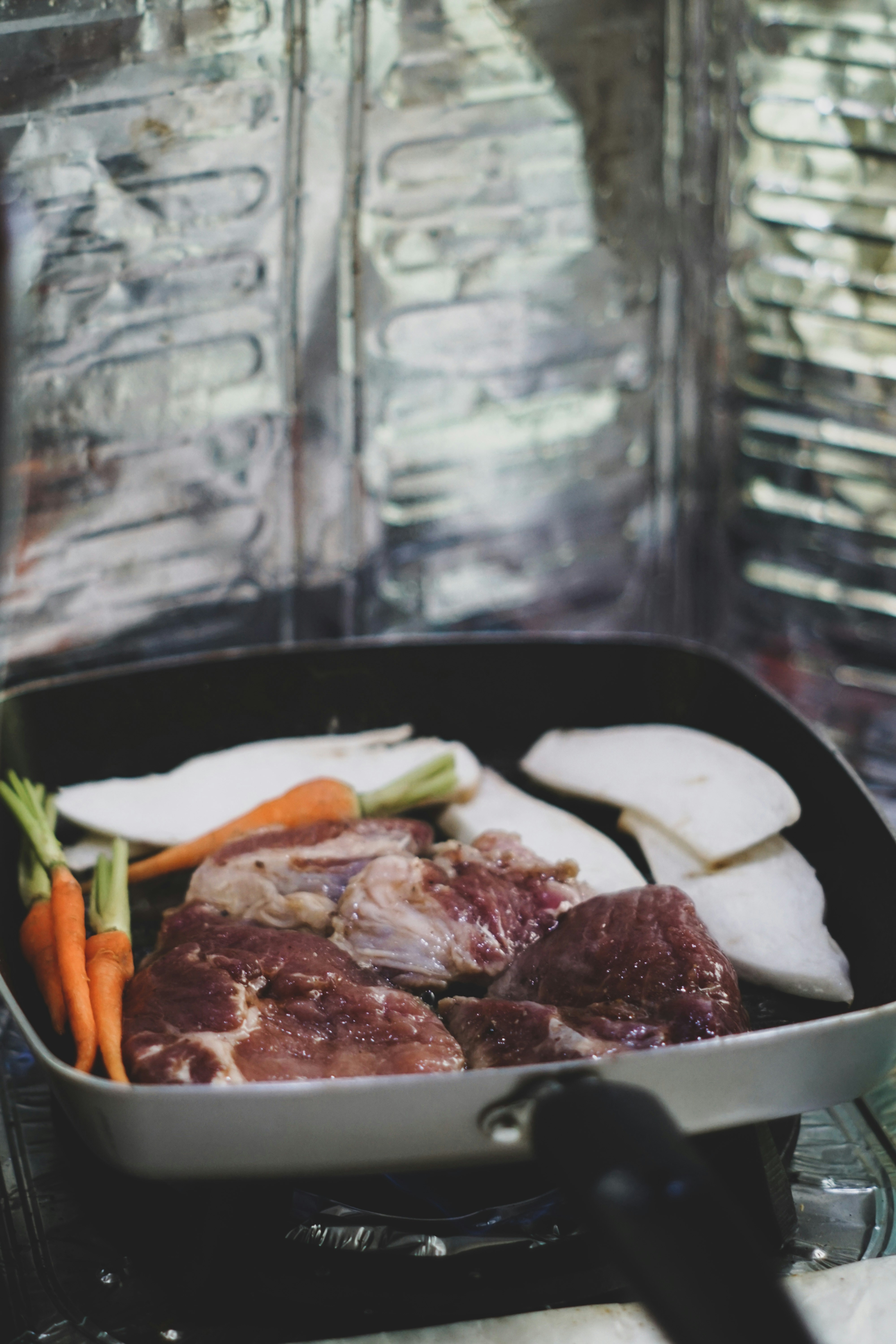 Skillet Sizzle: Beef Medallions and Carrots Caramelizing on a Gas Flame