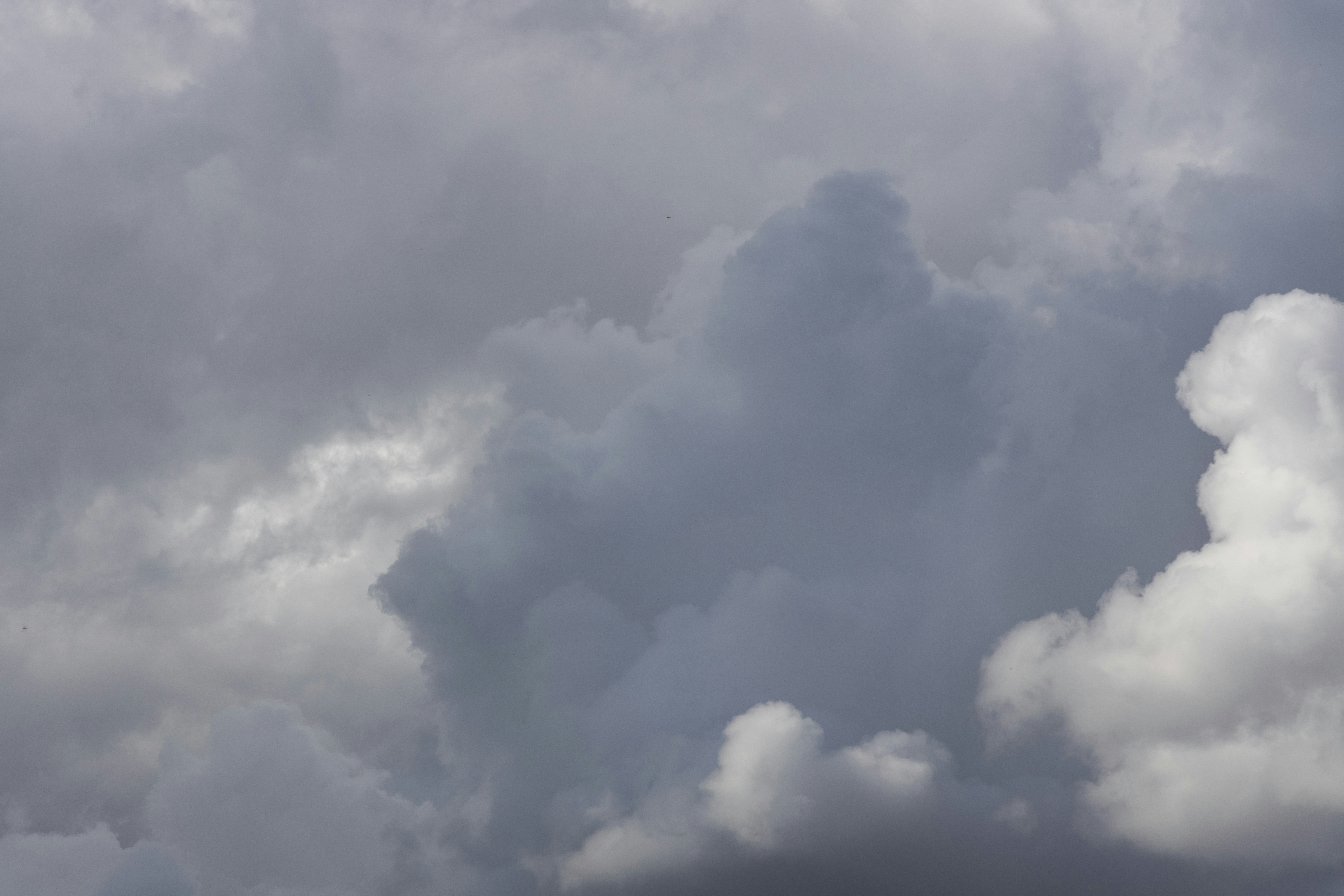 Dramatic cloud formations swirl in a moody sky, hinting at an impending storm. The interplay of light and shadow adds depth to the atmospheric scene.