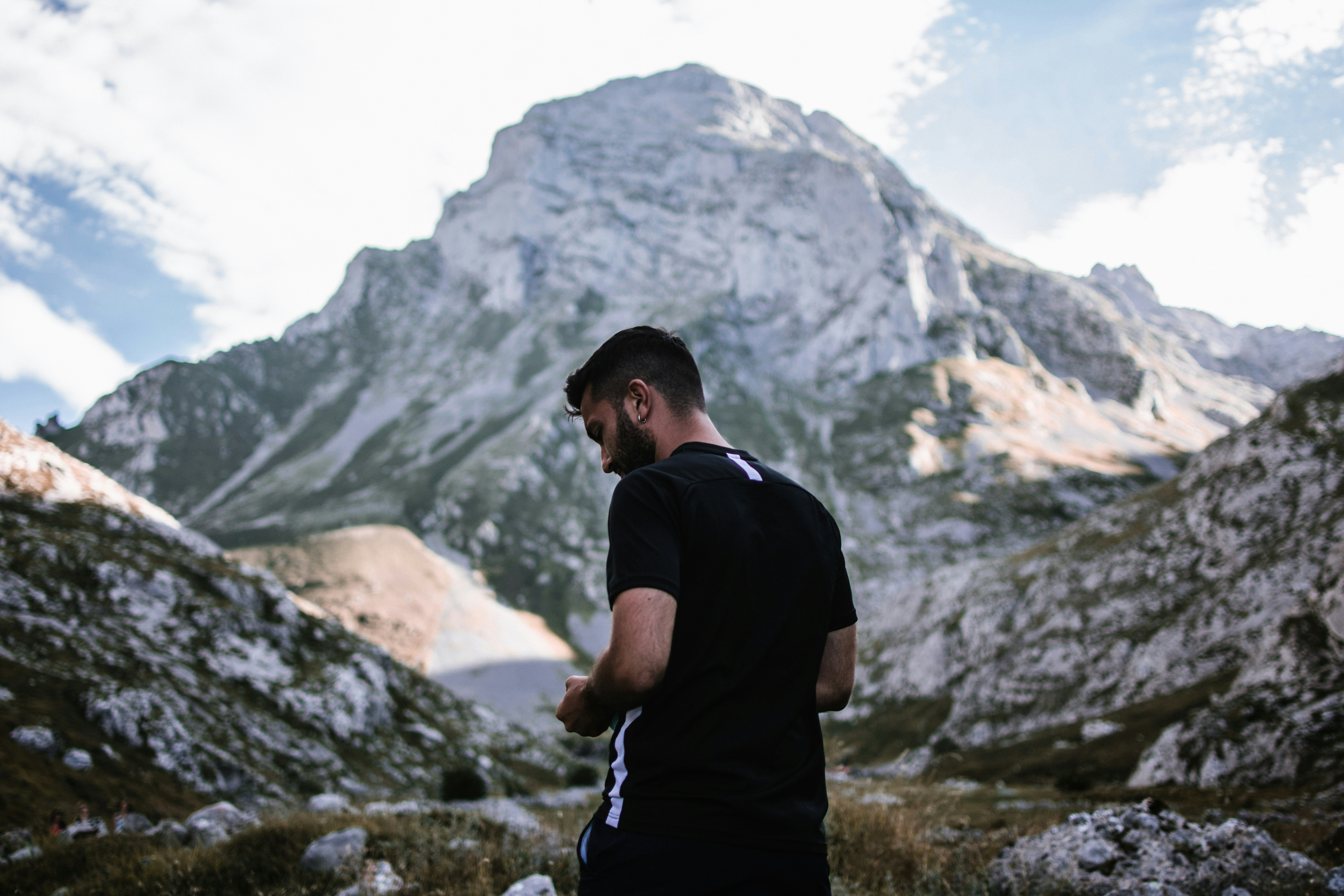Lone Figure in Black Framed by a Looming Alpine Peak