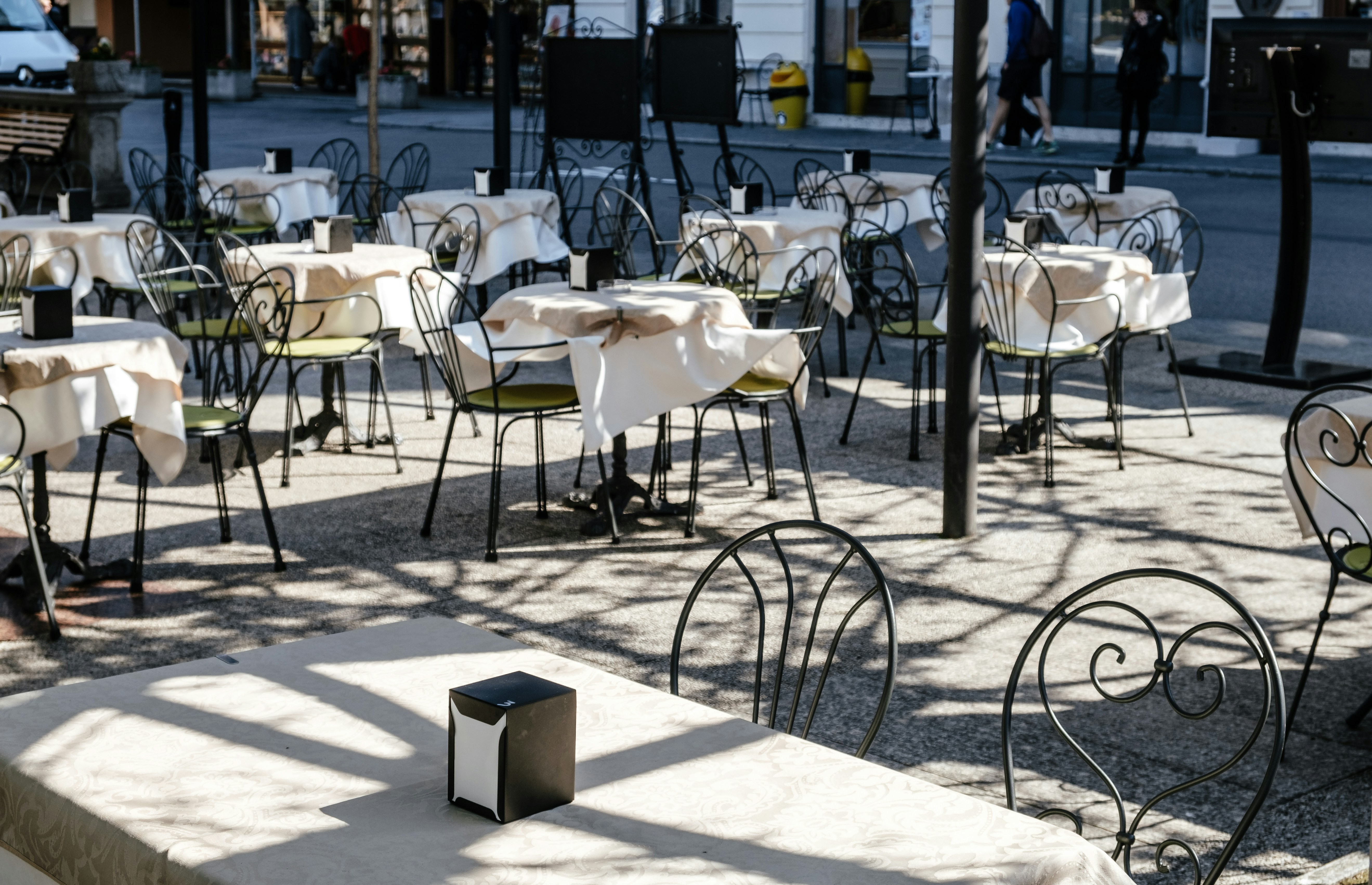 Lone Black Box on a Sunlit Café Terrace