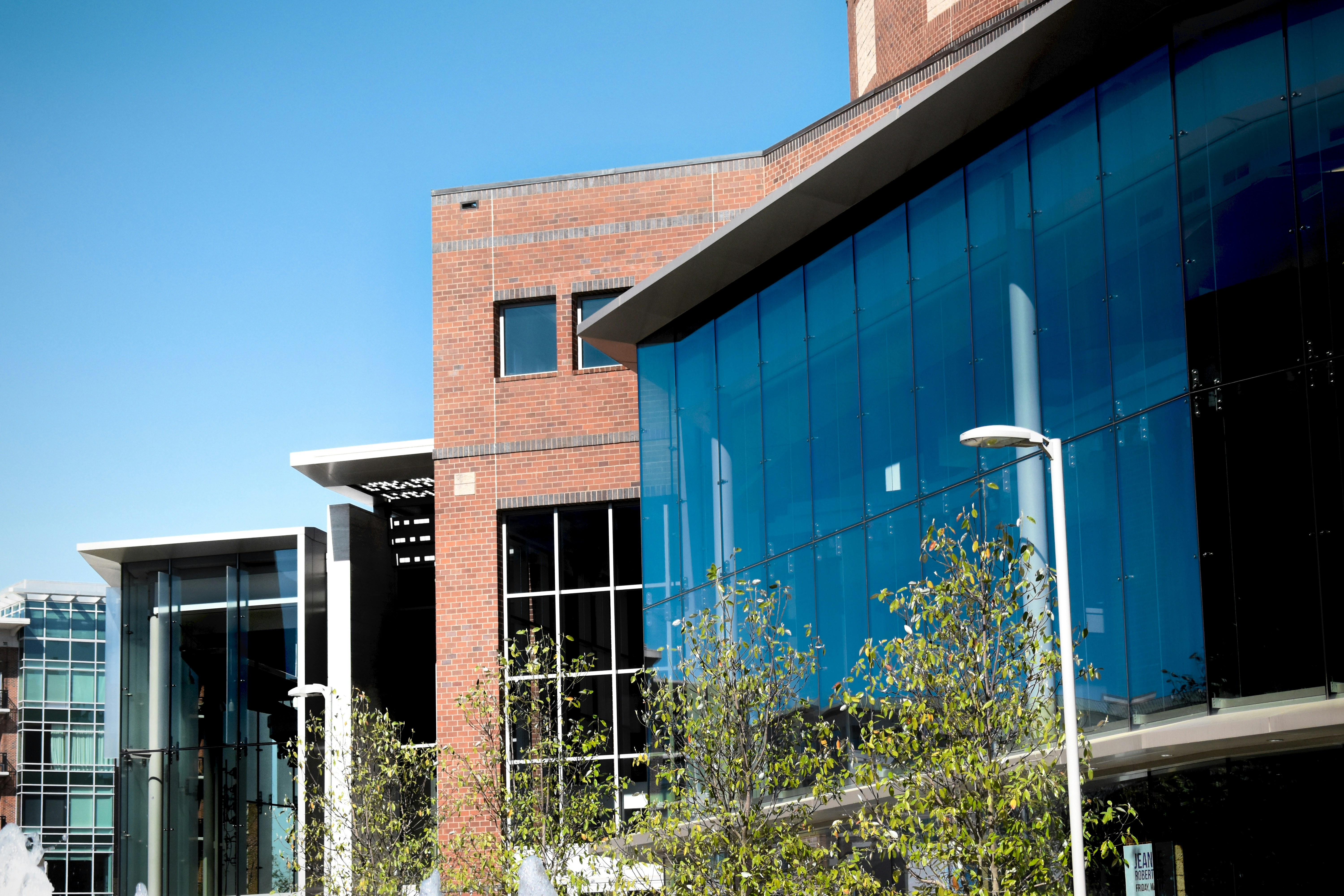 Contemporary building with glass and brick elements under a clear blue sky.