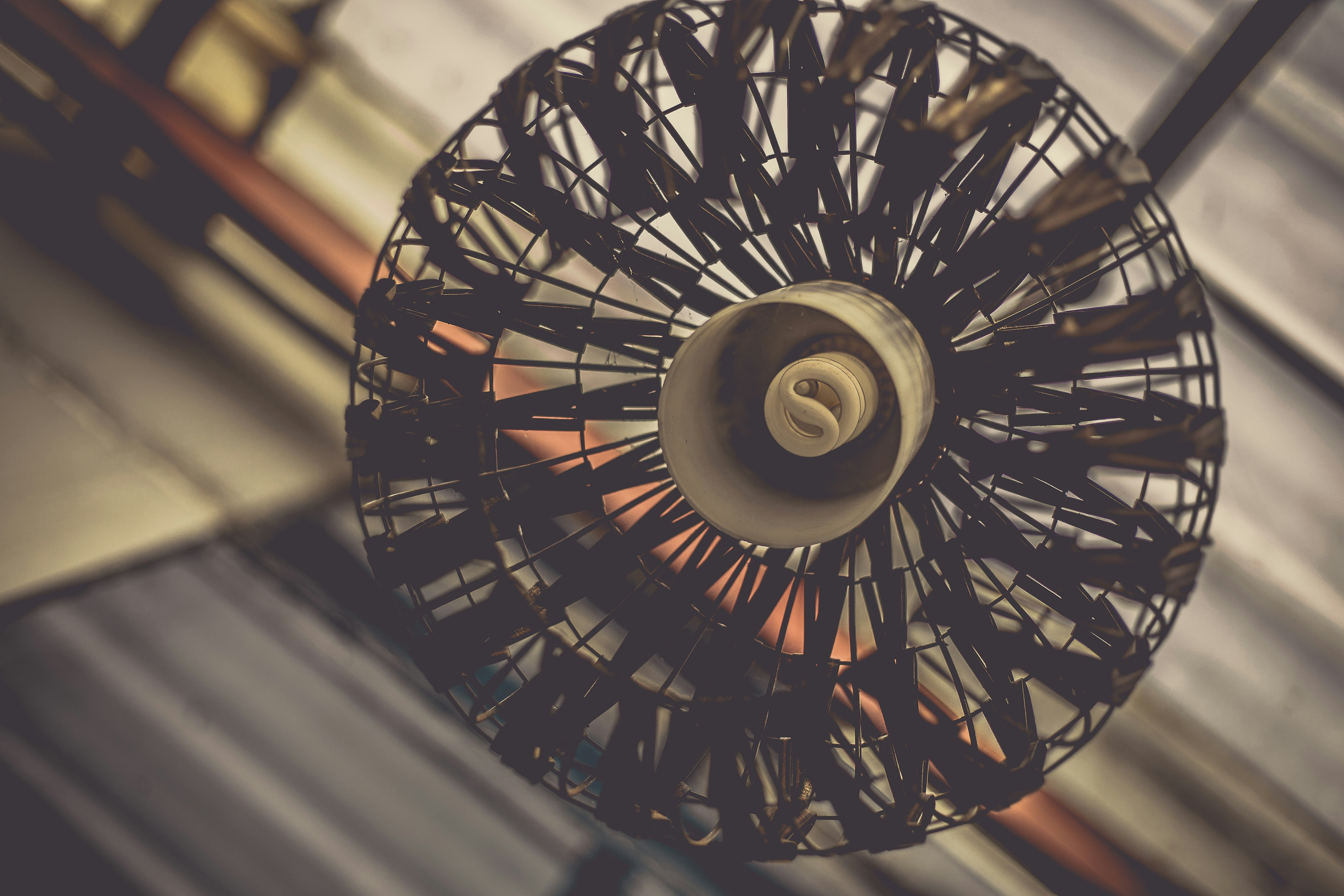 Intricate overhead light fixture casting geometric shadows in an industrial setting.