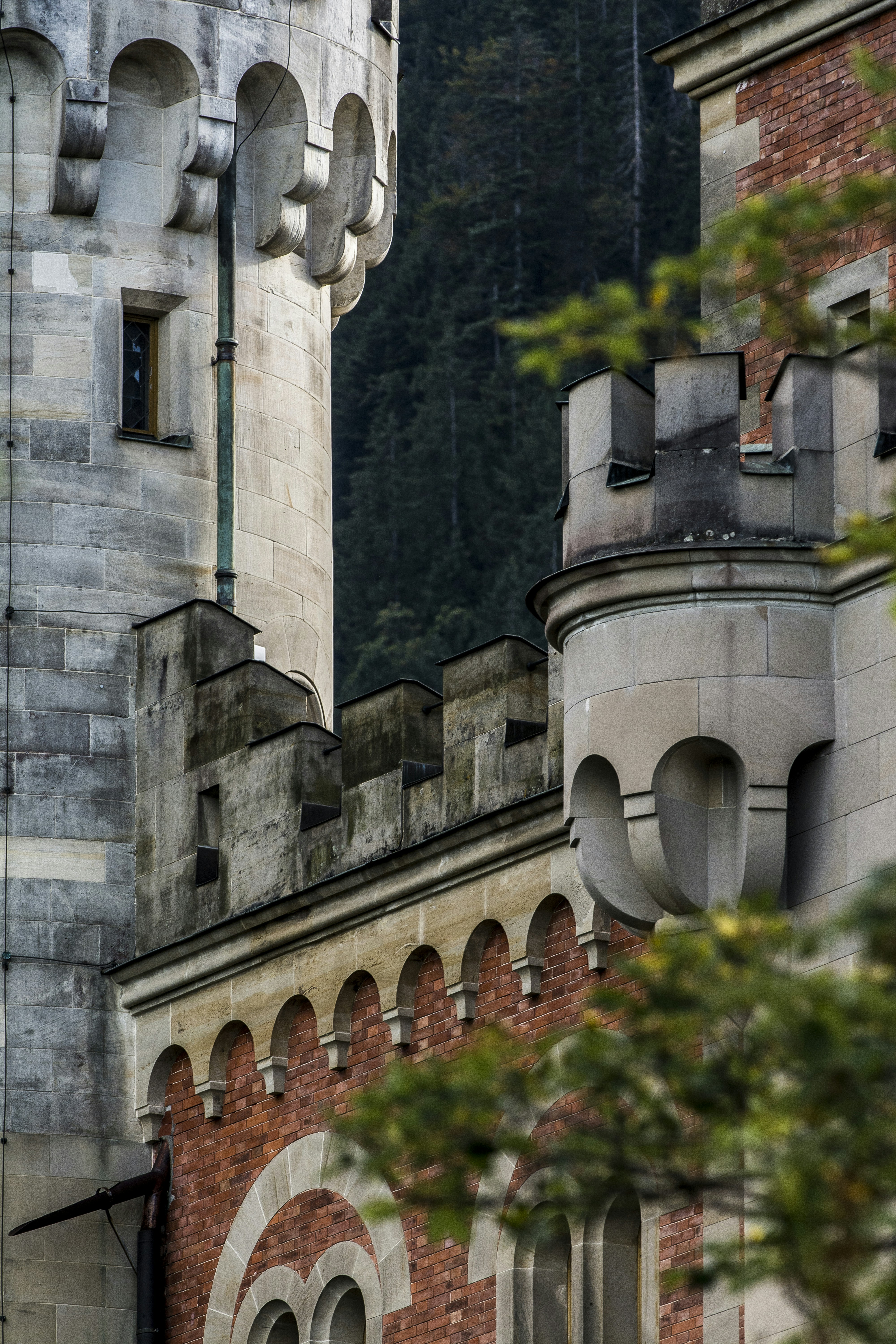 Stone Turret Over Brick Battlements Framed by a Forest Backdrop