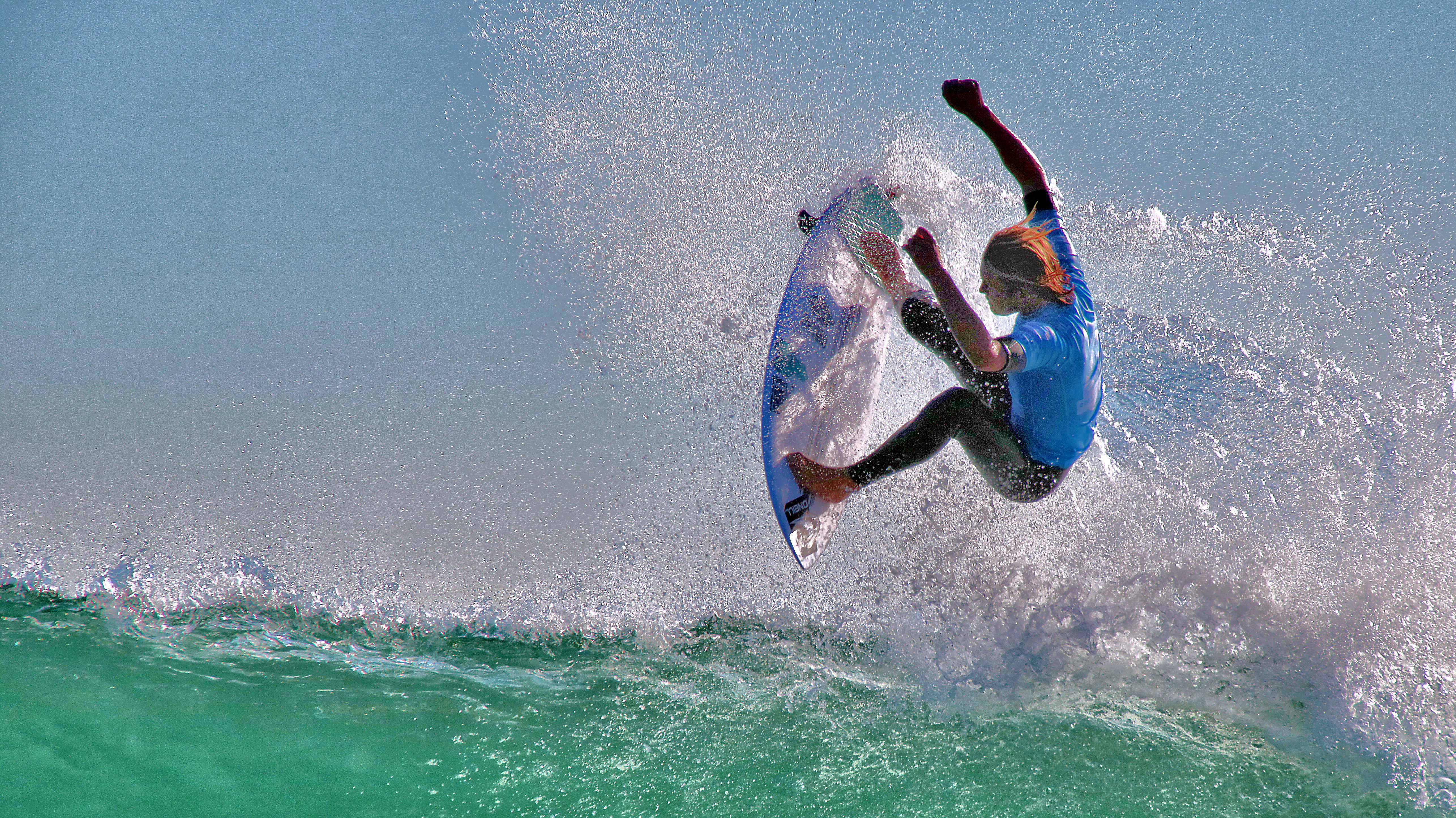 Aerial Surf Trick Over a Cresting Green Wave