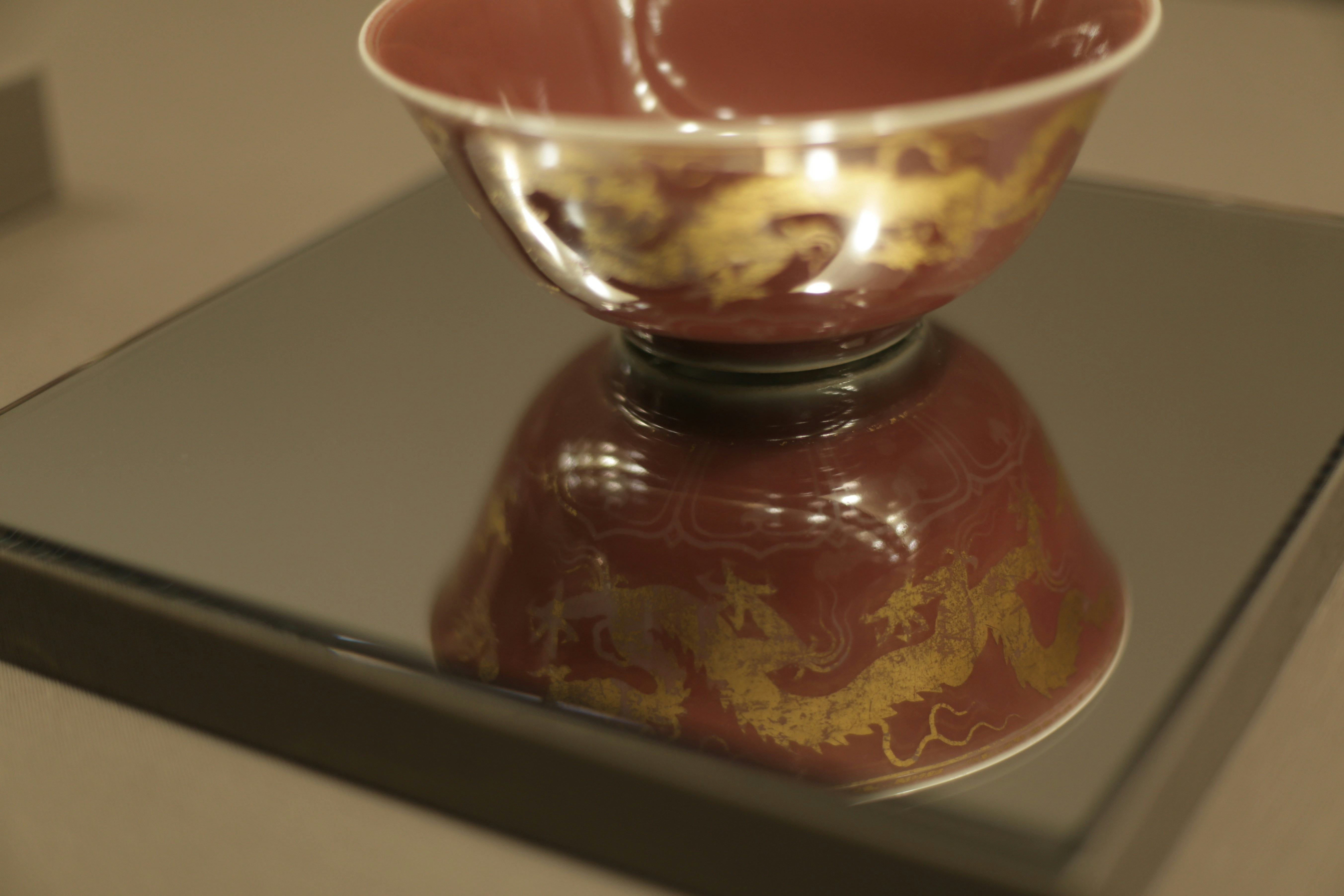 Reflective Bowl: Gold Dragon Motifs on a Velvet Pedestal