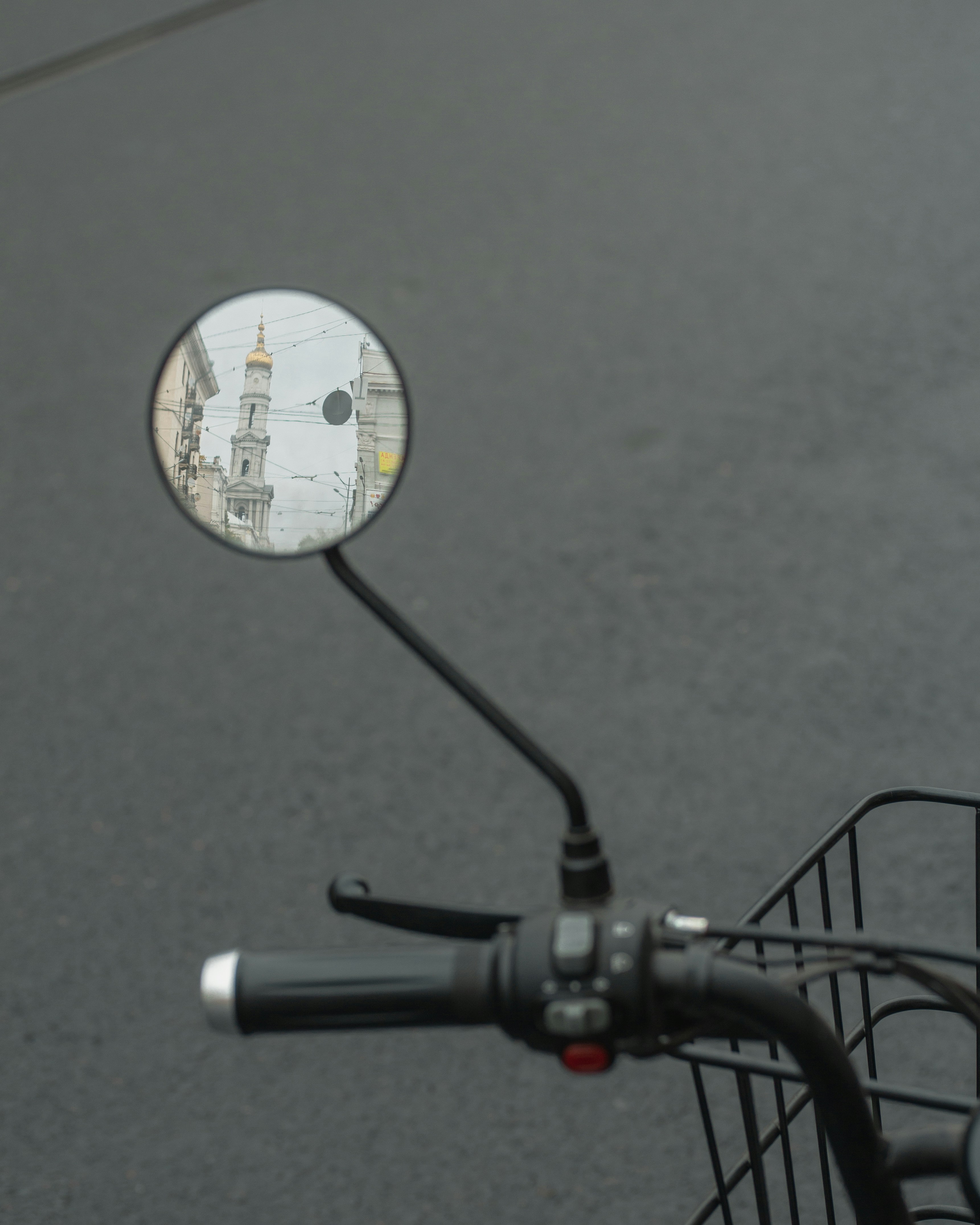 Mirrored Street: A Bike Handlebar Framing a Distant Clock Tower