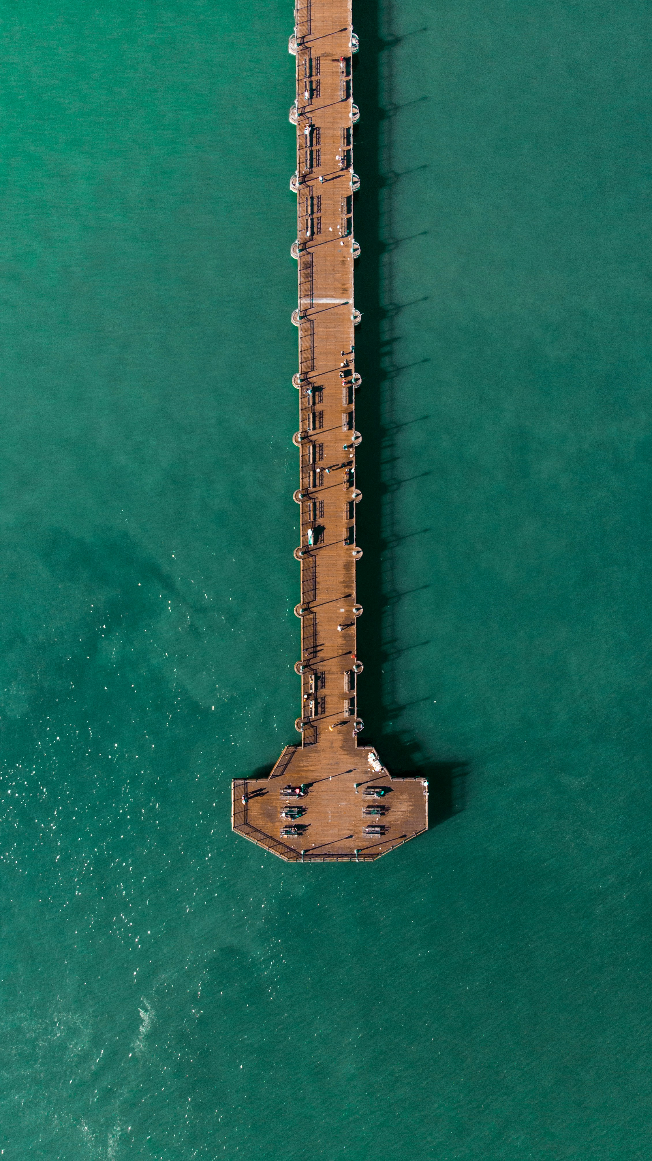 an aerial view of a pier in the middle of the ocean